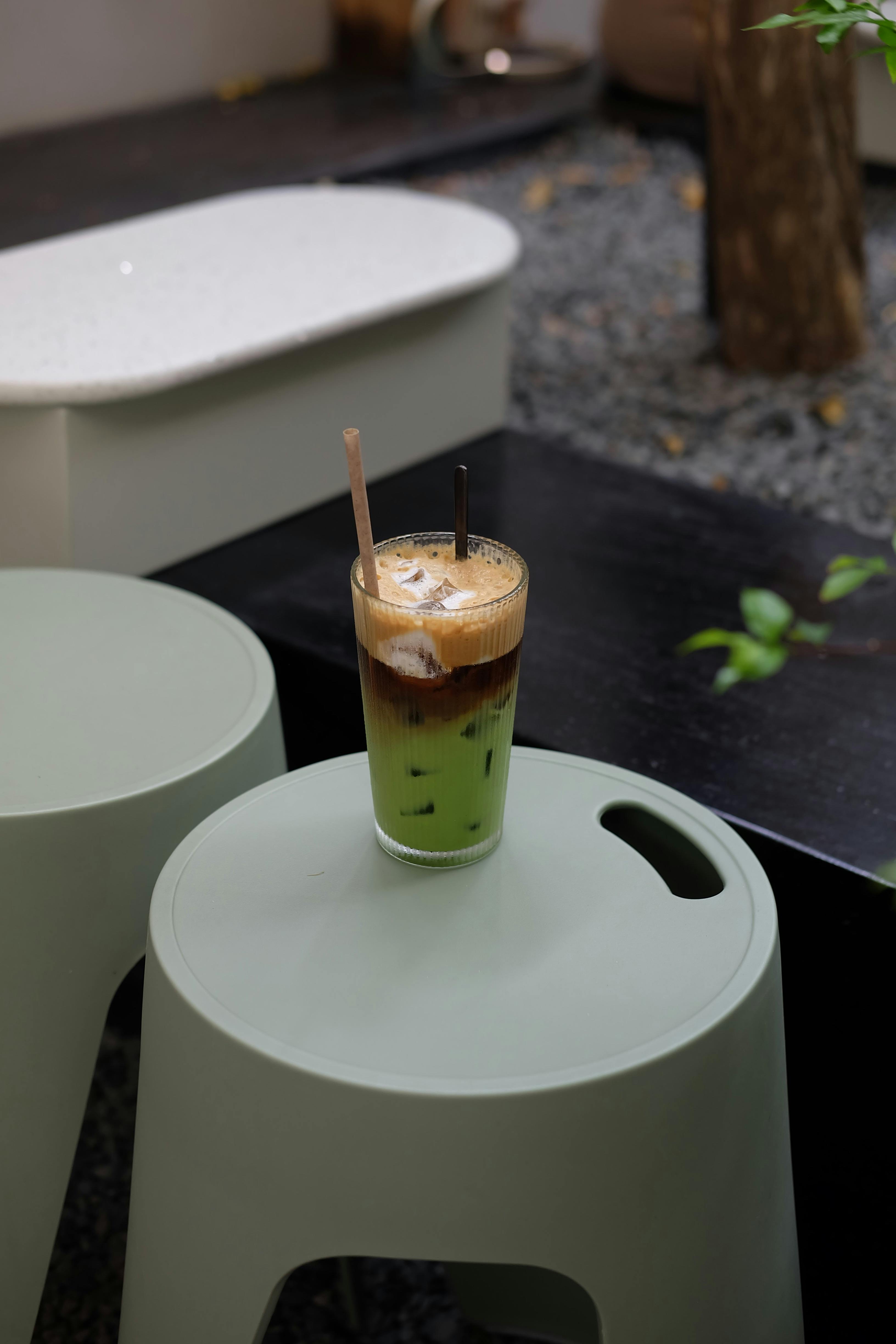 A Drink with a Straw Standing on a Stool in a Cafe · Free Stock Photo