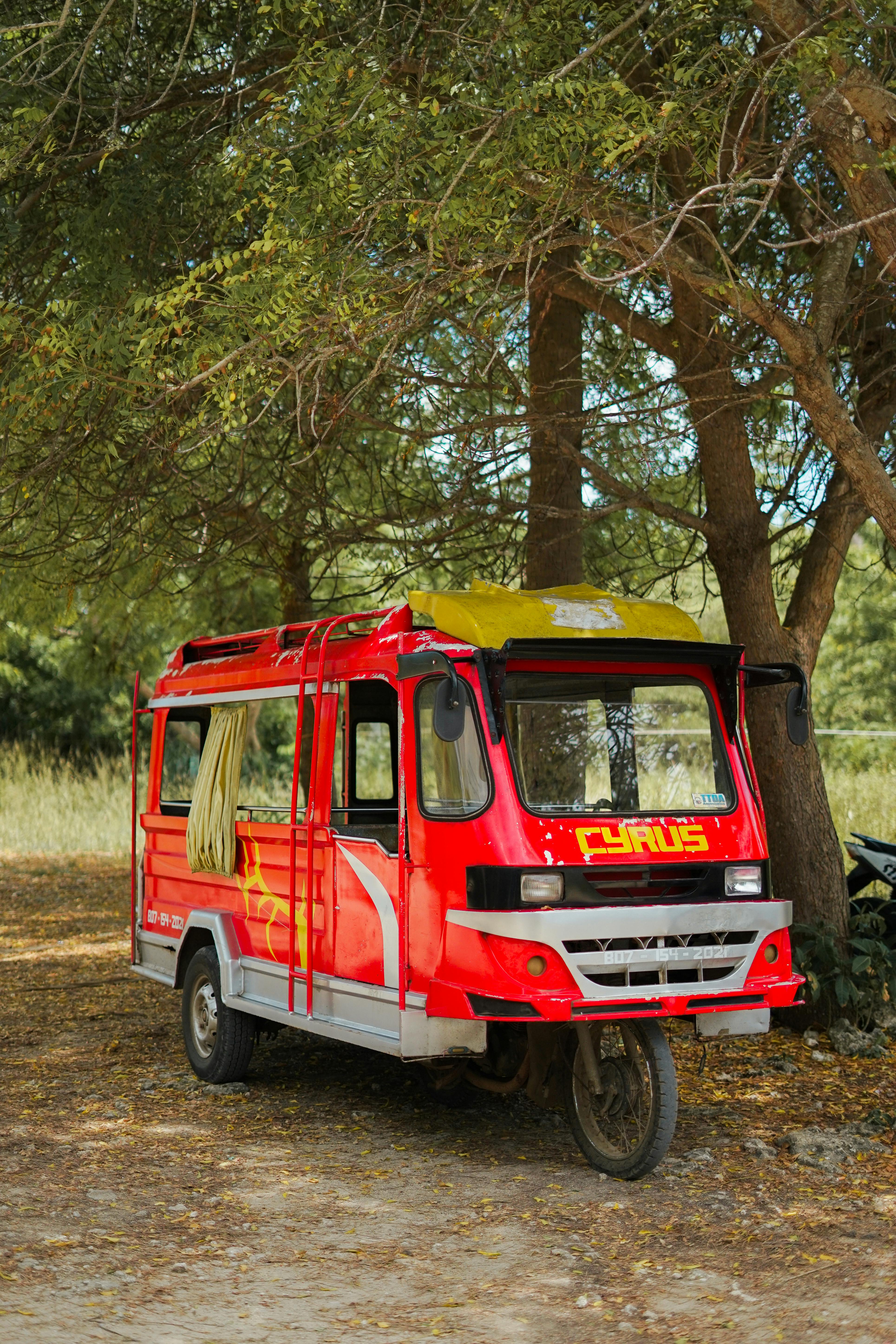 Photo of a Red Auto Rickshaw Parked under the Trees · Free Stock Photo