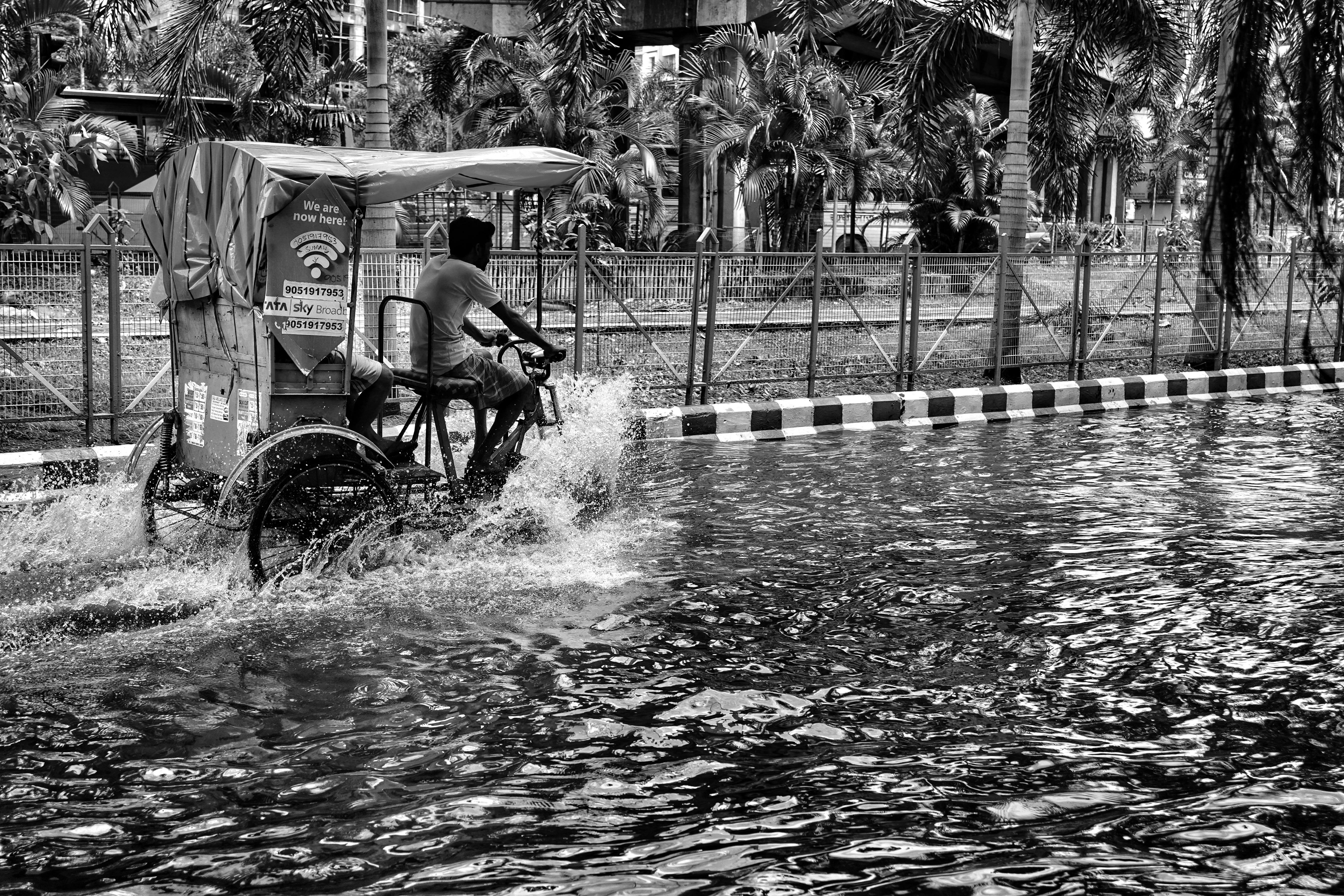 Man Riding Rickshaw during Flood · Free Stock Photo