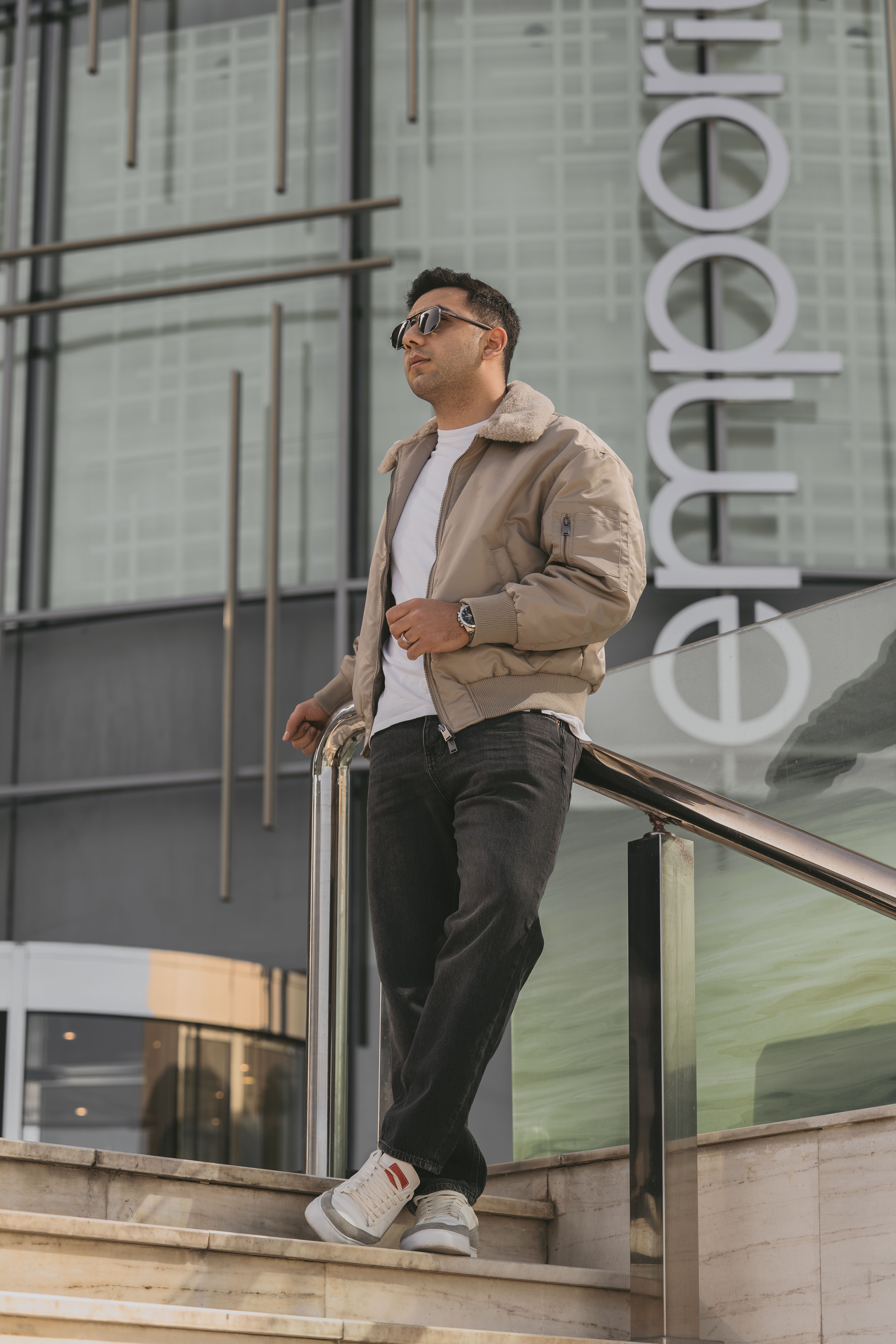 Man Posing on the Stairs in front of a Mall · Free Stock Photo