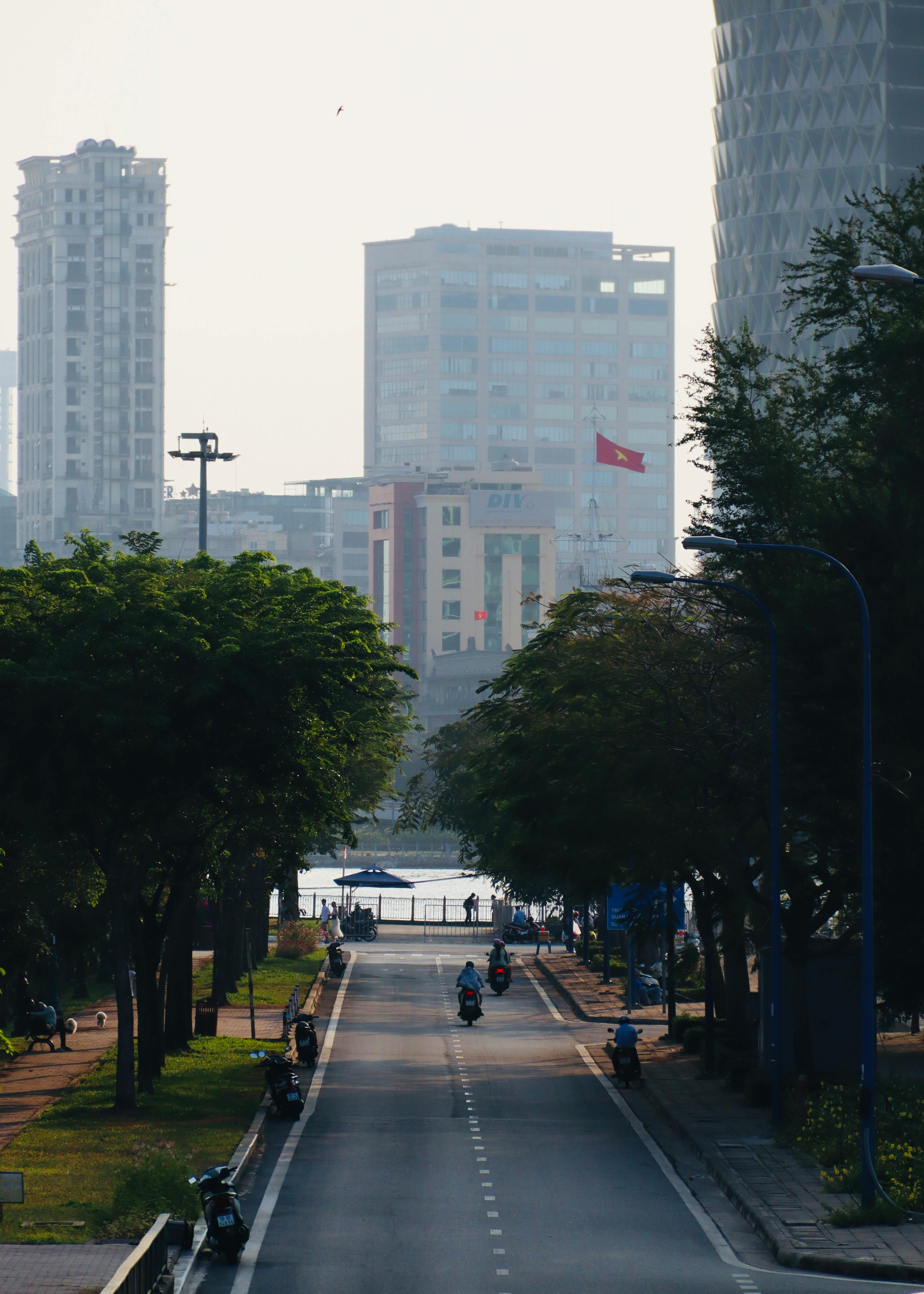 Motorcycles Driving on City Street with High Rise Buildings in Back ...
