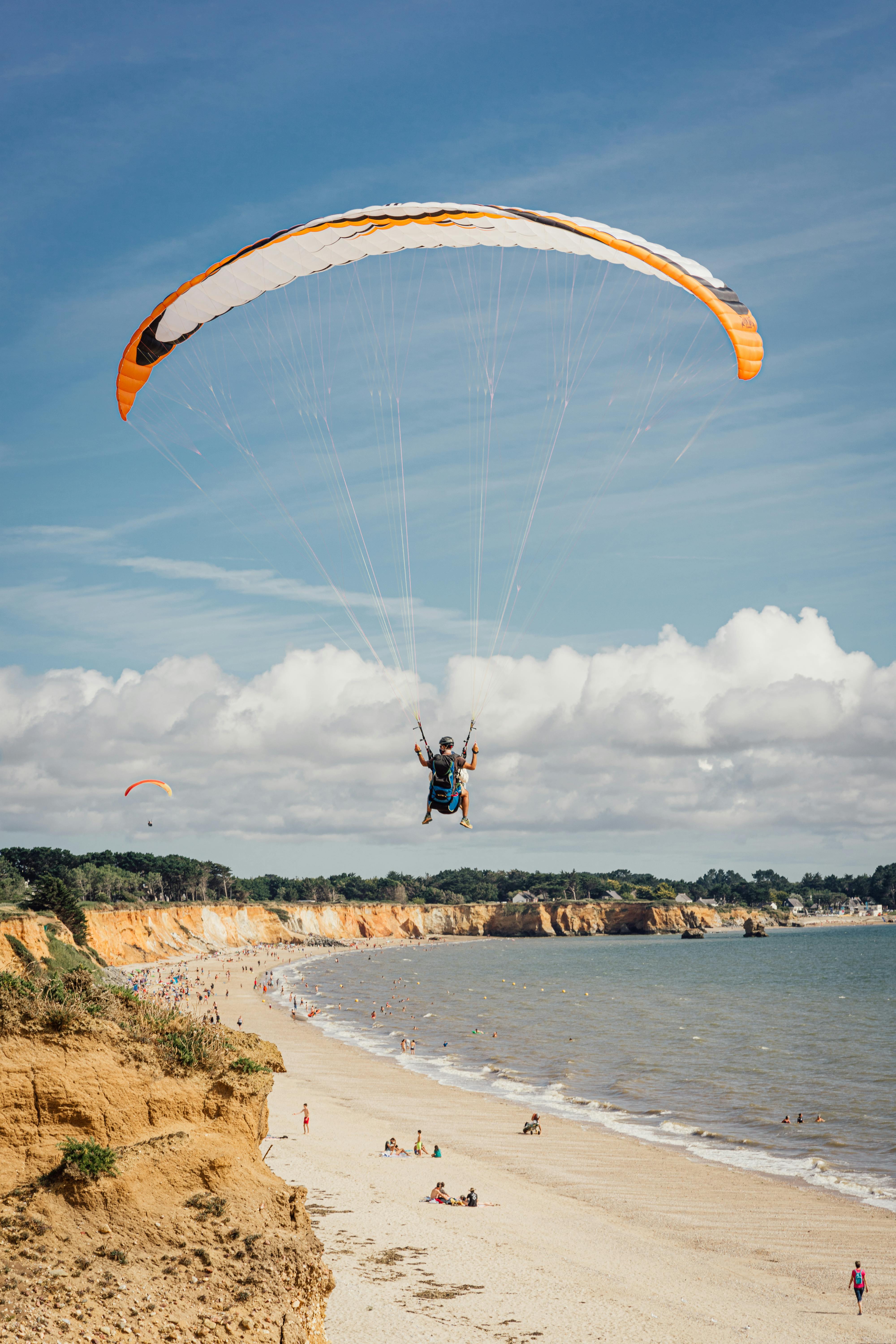 Back View of Couple Parachuting over Beach · Free Stock Photo