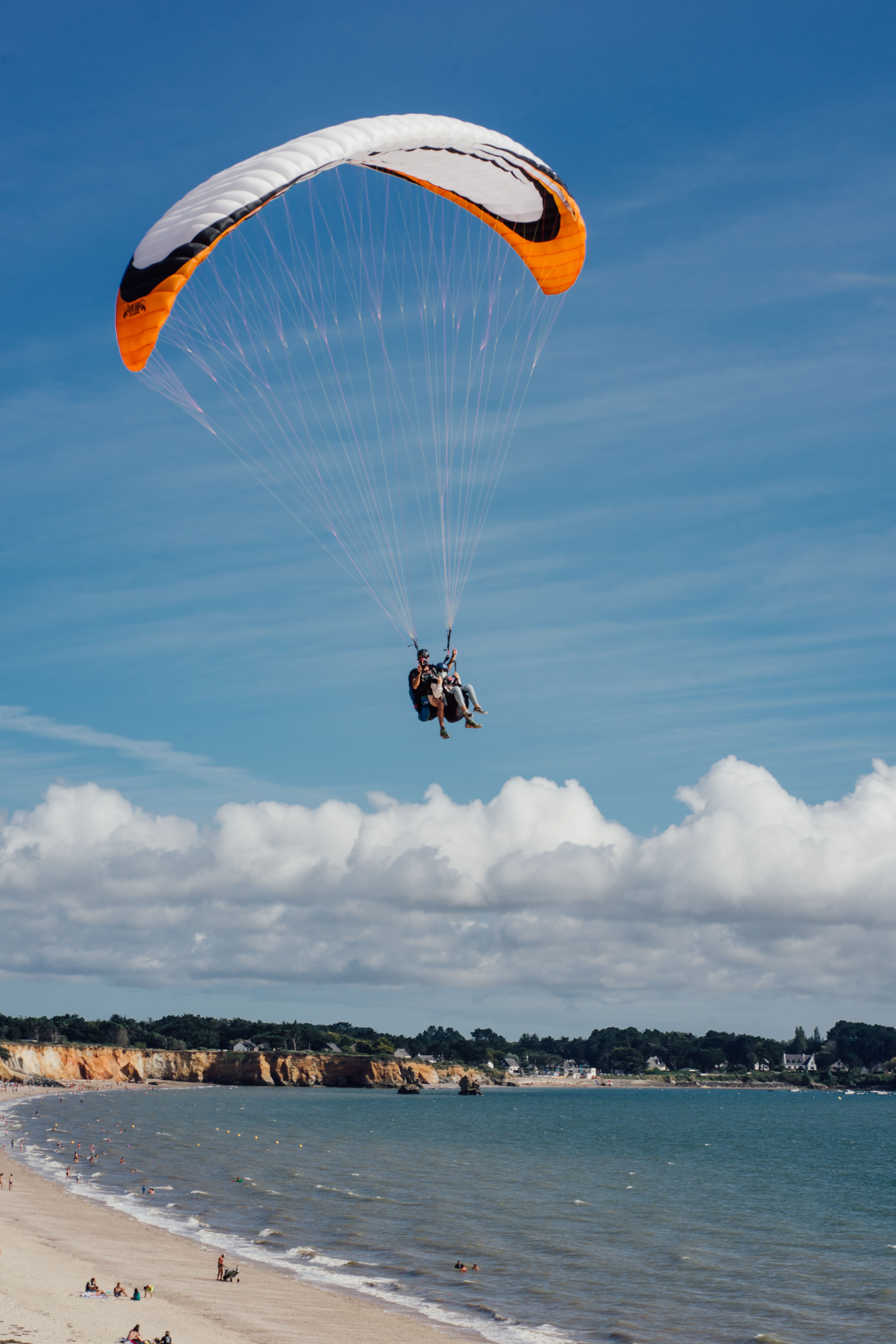 Couple Parachuting on Sea Coast · Free Stock Photo
