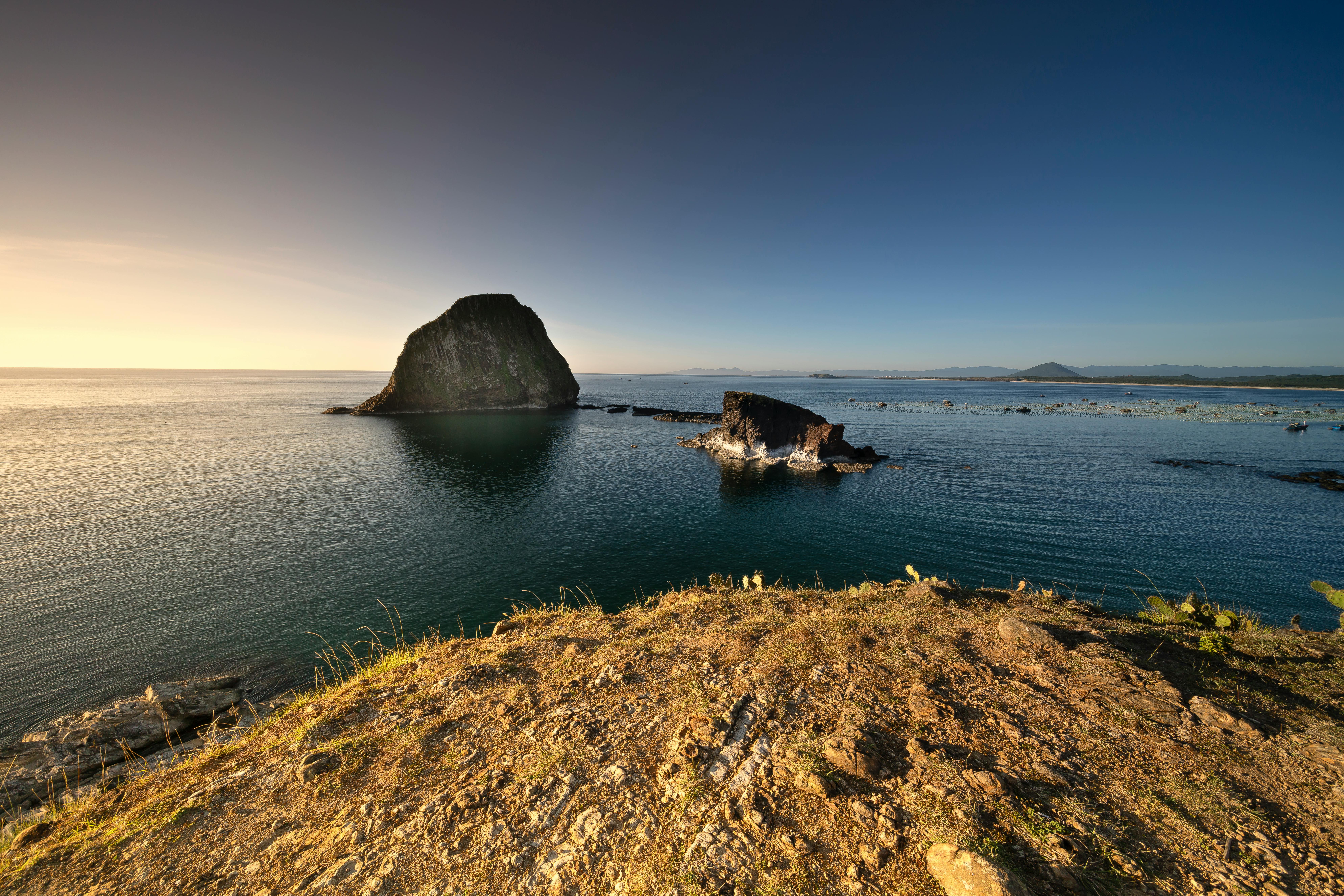 Brown Rock Formation on Sea Shore Under White Clouds · Free Stock Photo