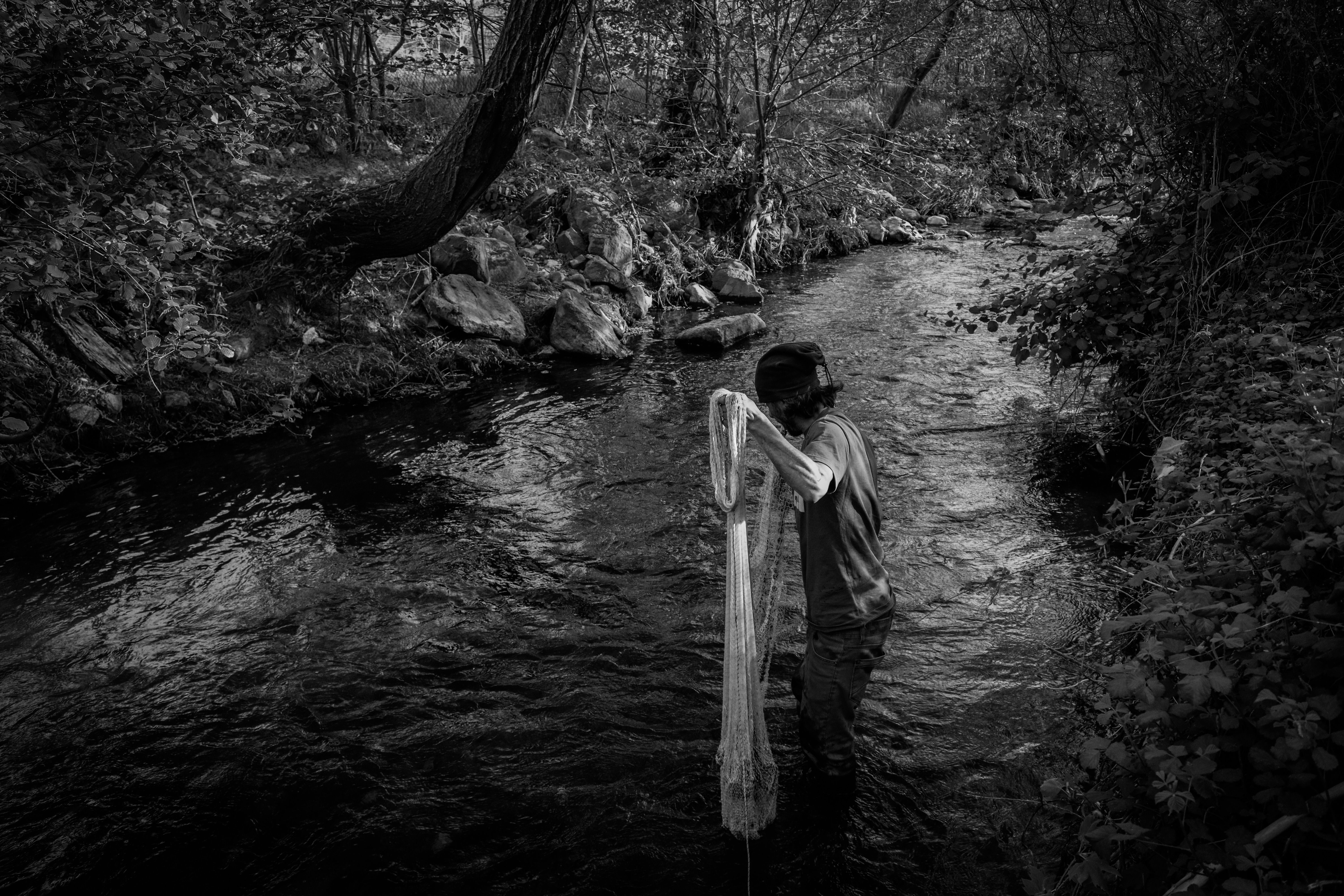 A man is standing in a stream with a white cloth · Free Stock Photo