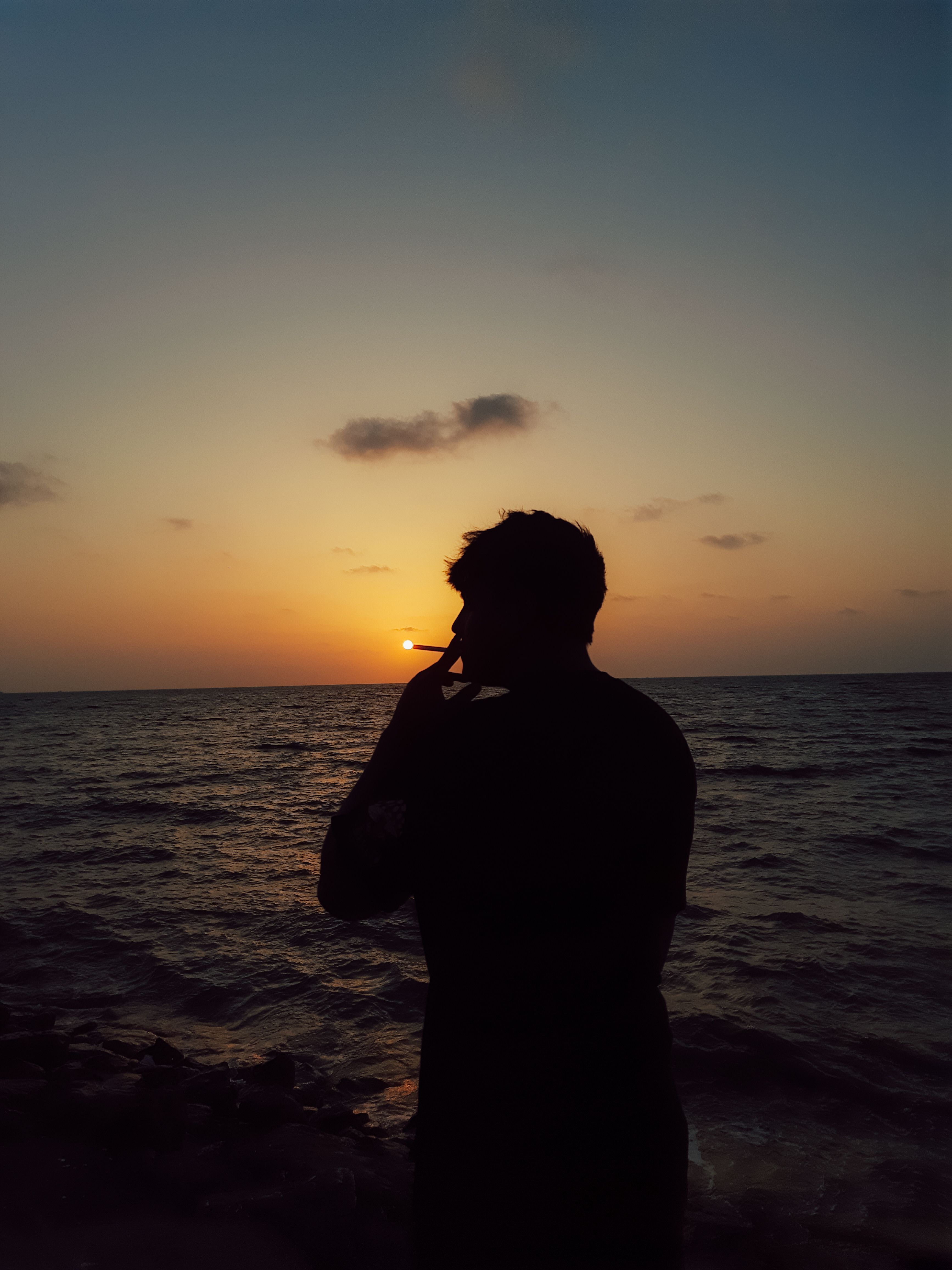 Man Standing and Smoking on Seashore · Free Stock Photo
