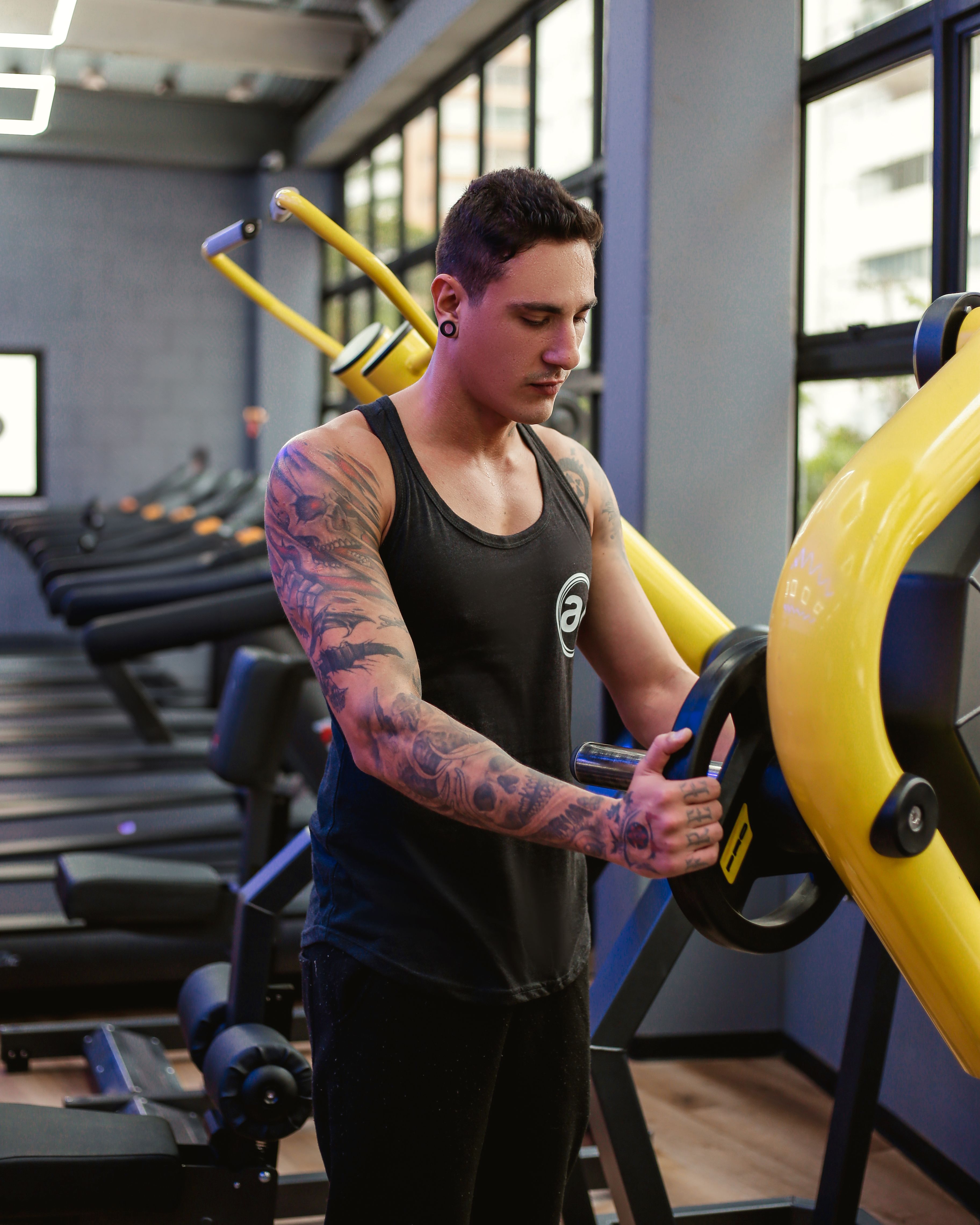 Man Preparing a Machine at the Gym for a Set · Free Stock Photo