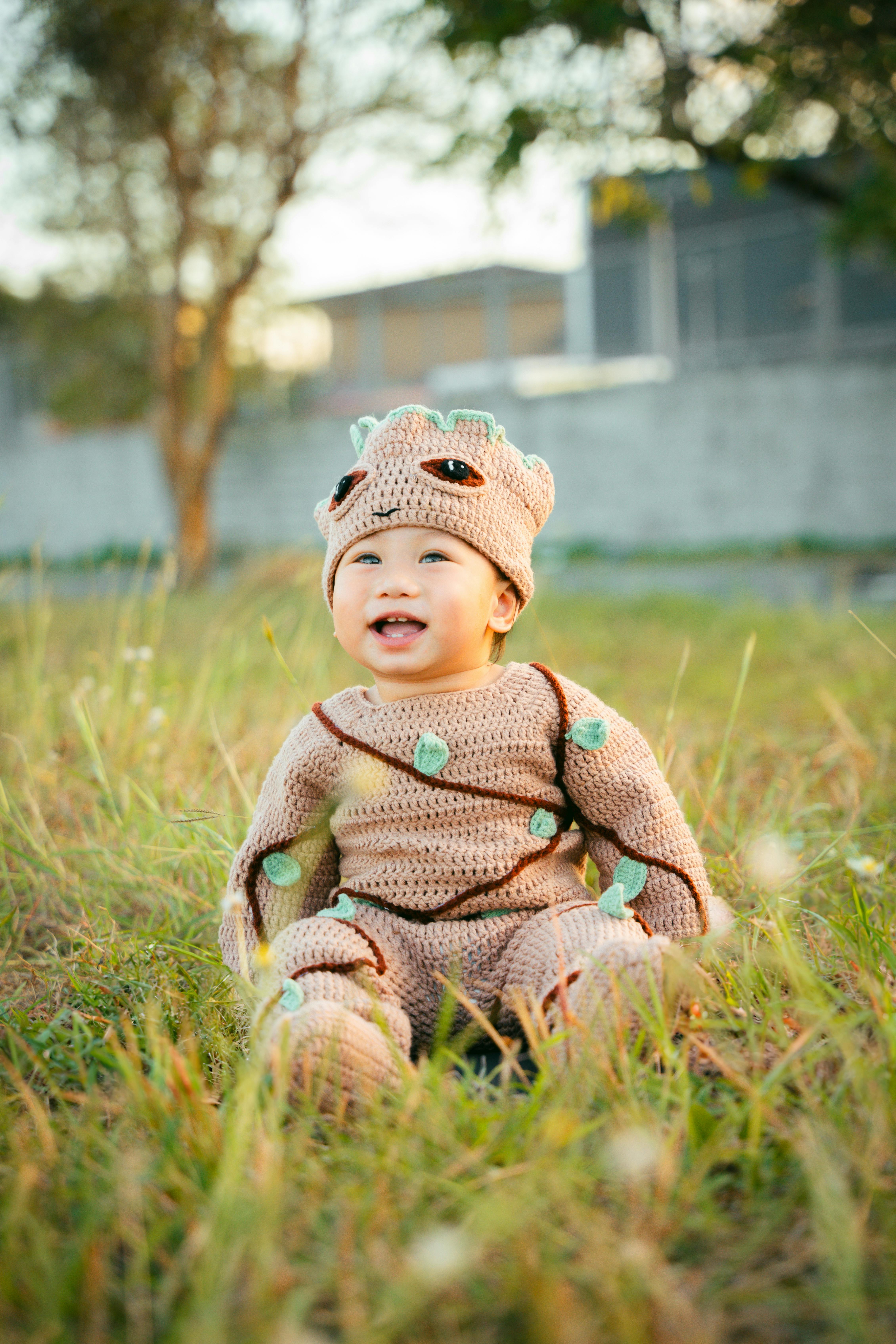 Little Baby Wearing Woolen Costume on a Meadow · Free Stock Photo