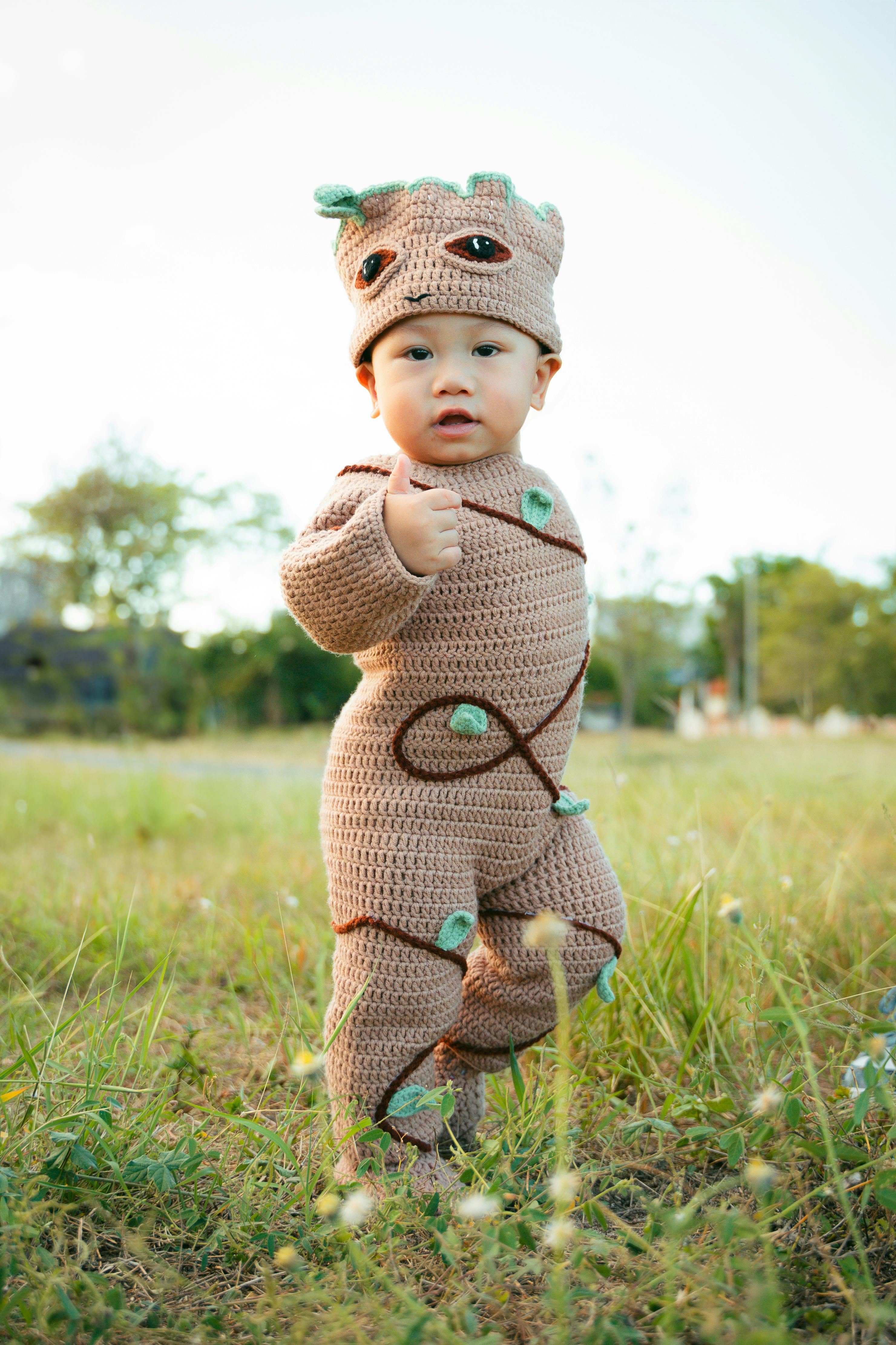 Little Baby Wearing Woolen Costume on a Meadow · Free Stock Photo