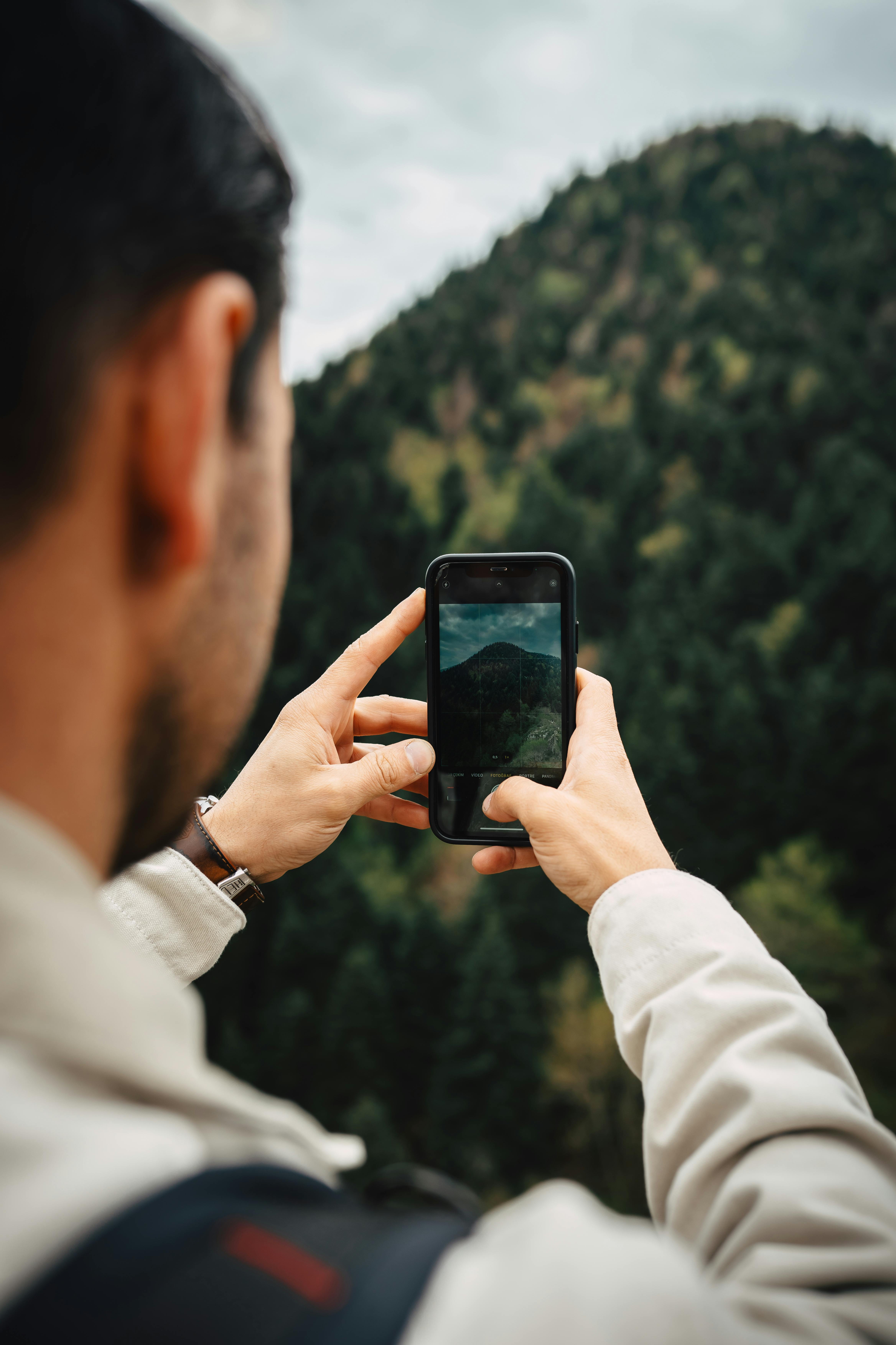 Back View of Man Taking Pictures with Smartphone · Free Stock Photo
