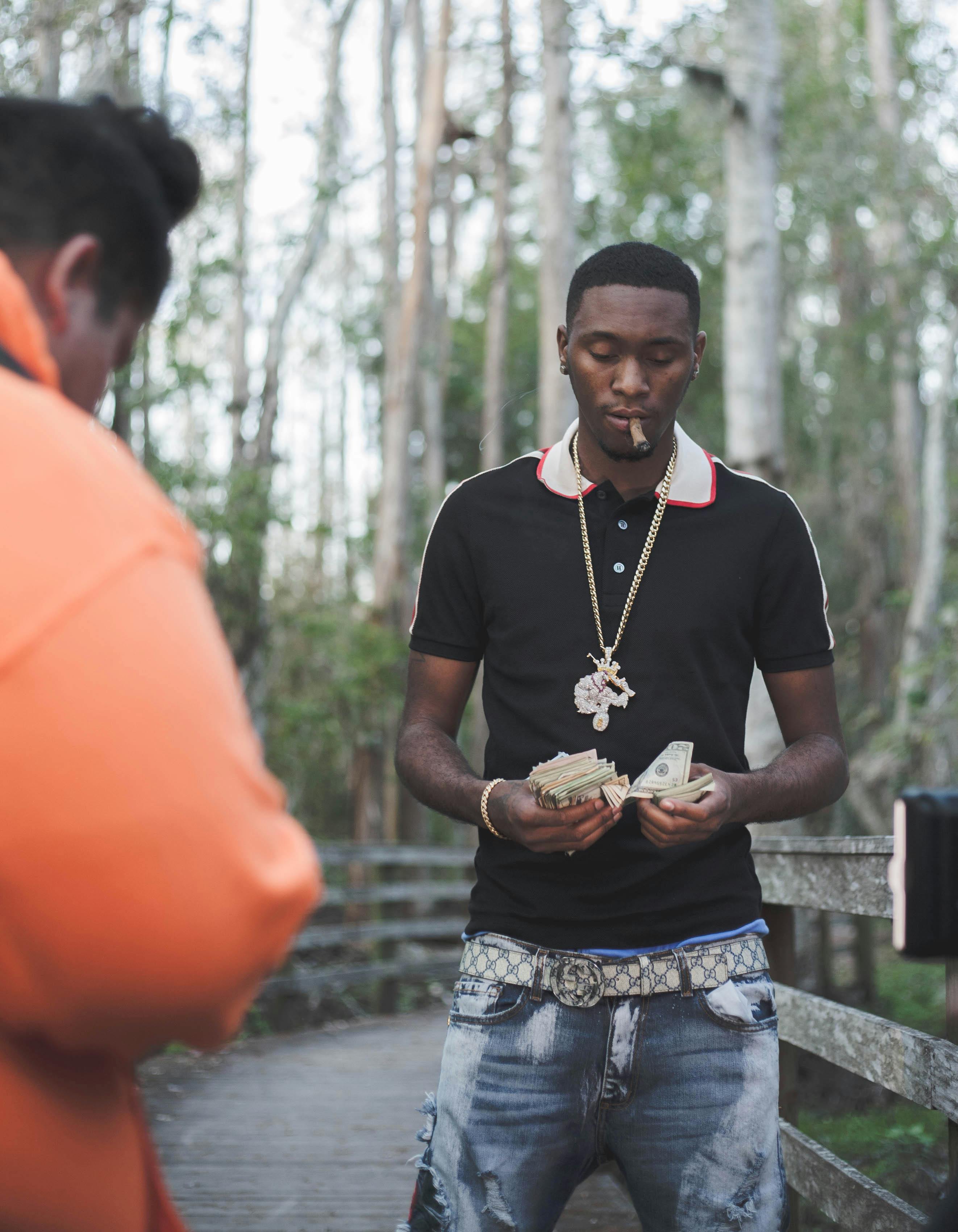 Young Man Counting Money while Smoking a Cigar · Free Stock Photo