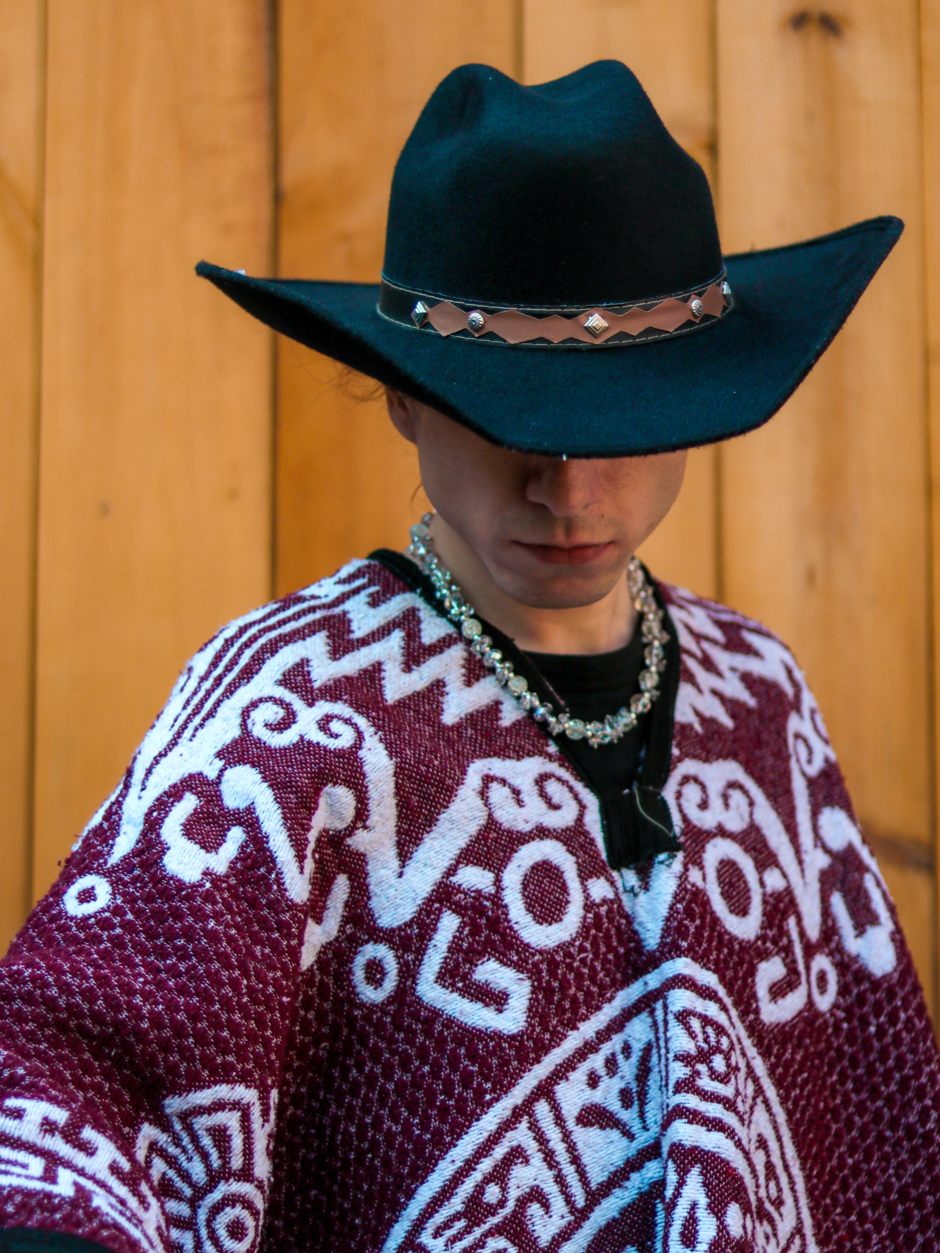 Photo of a Man Wearing a Patterned Poncho and a Hat · Free Stock Photo
