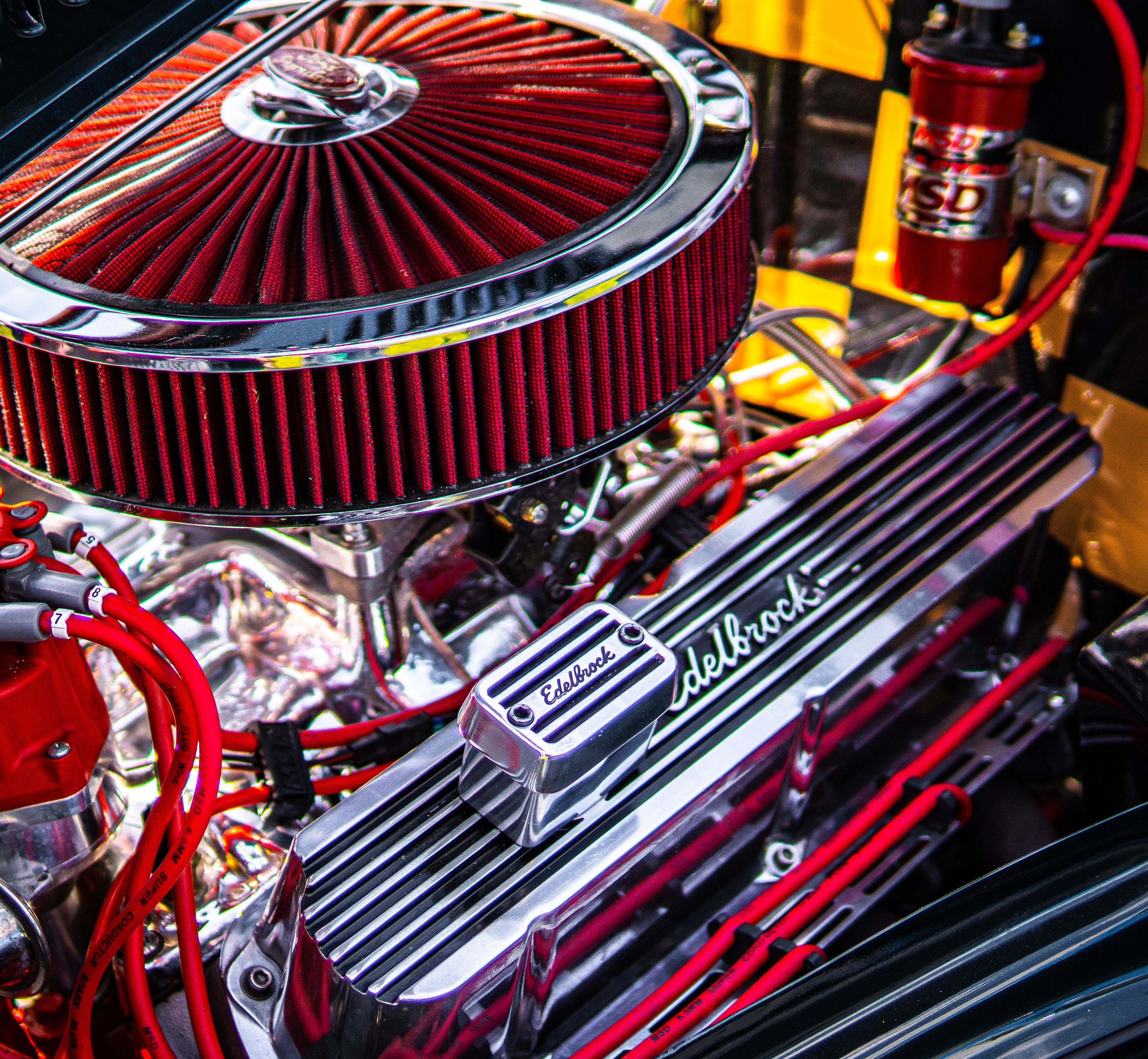 A close up of a car engine with red and black paint · Free Stock Photo