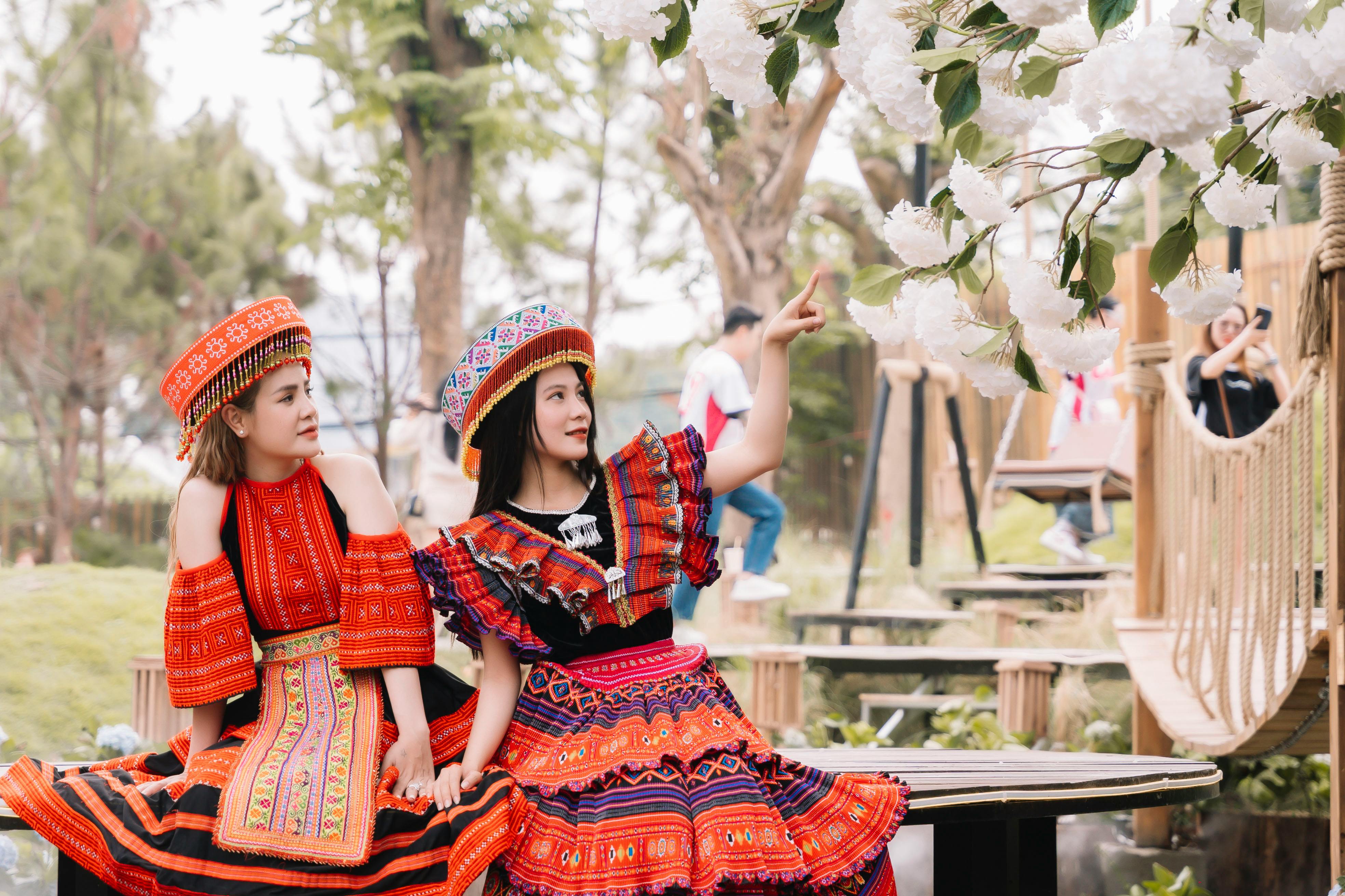 Two women in traditional costumes sitting on a bench · Free Stock Photo
