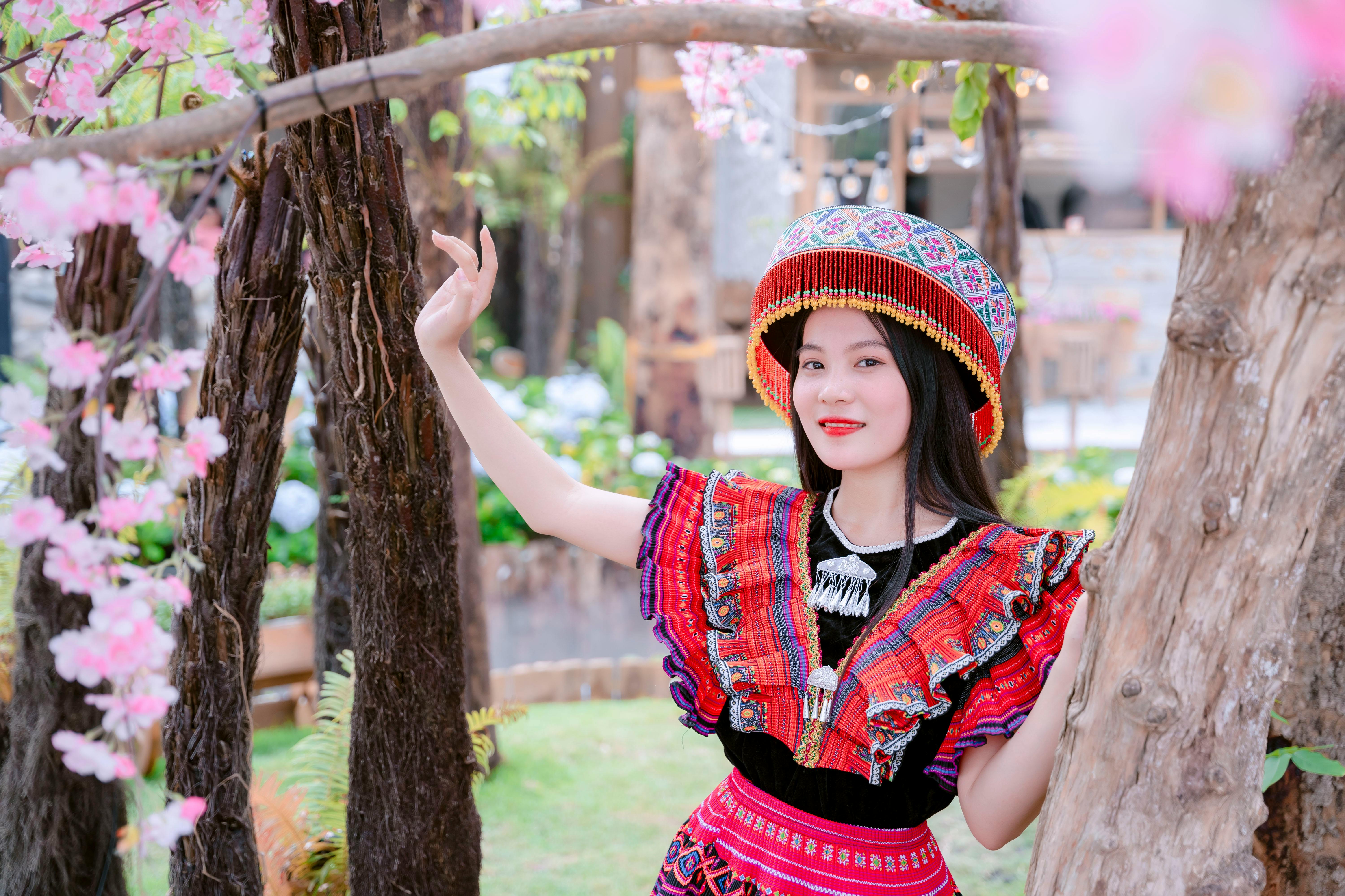 A Young Woman in Traditional Dress Standing between Trees · Free Stock ...