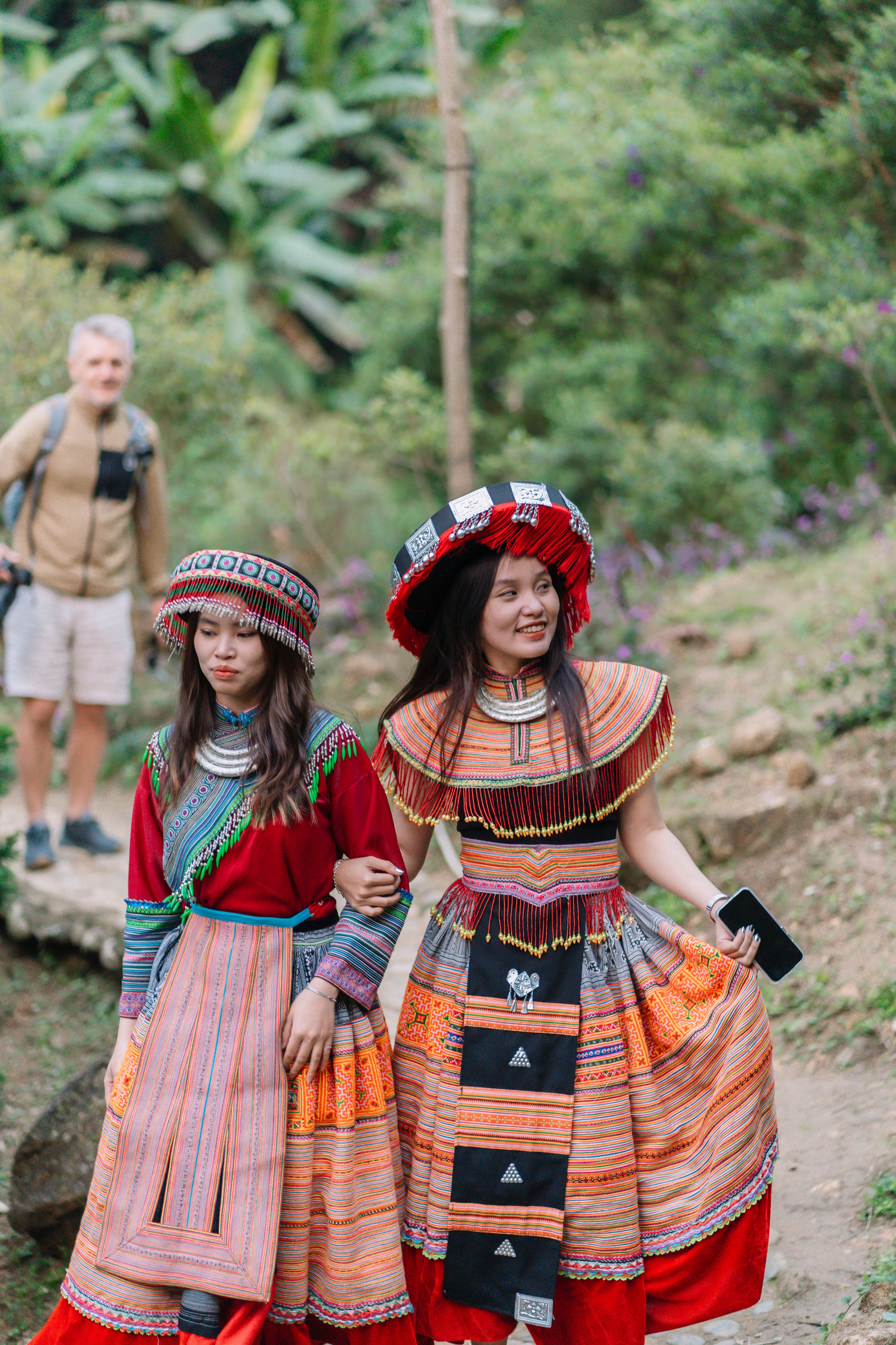 Two women in traditional clothing walking on a path · Free Stock Photo