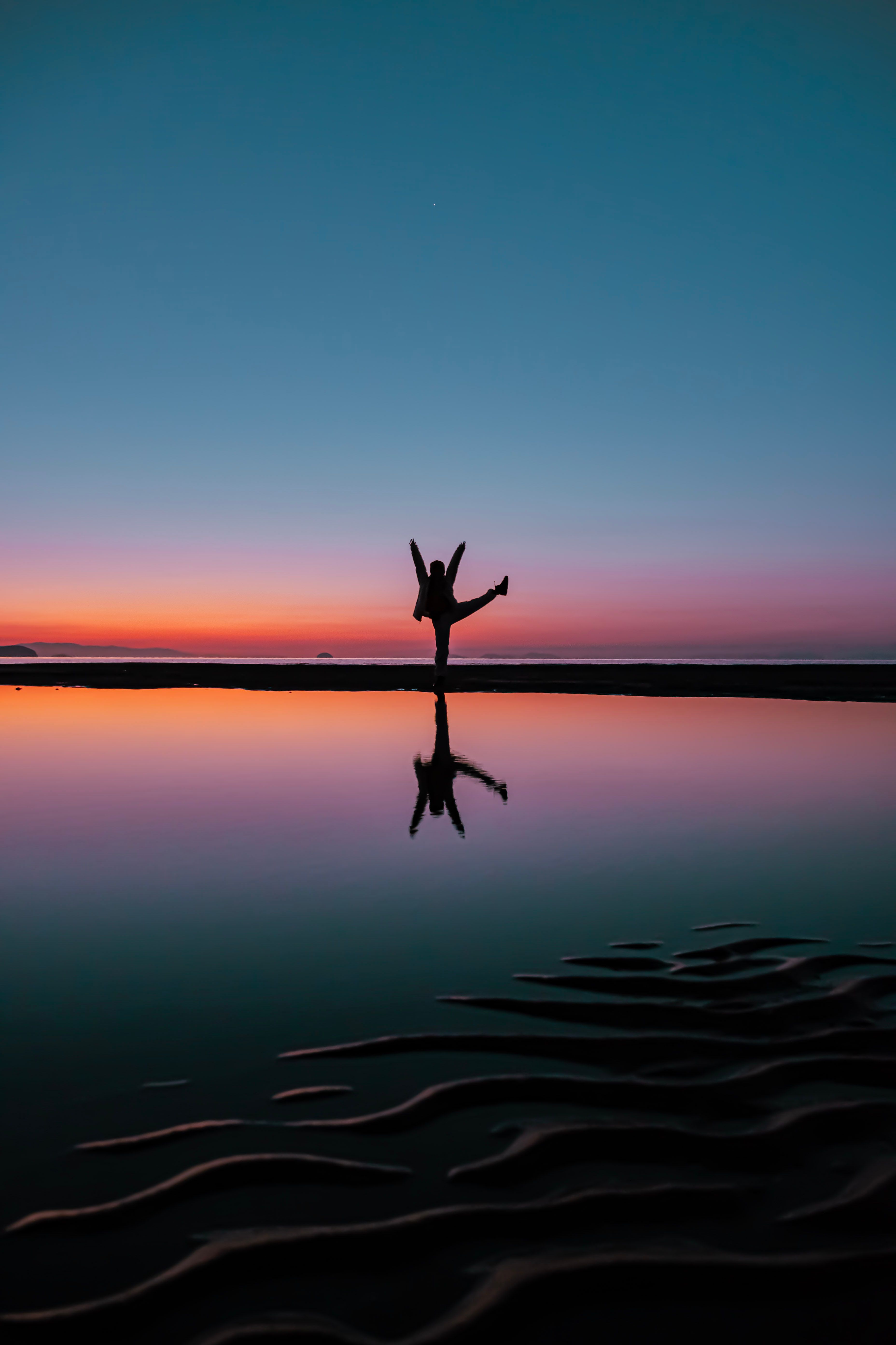 Person Posing with Arms and Leg Raised on Sea Shore at Dusk · Free ...