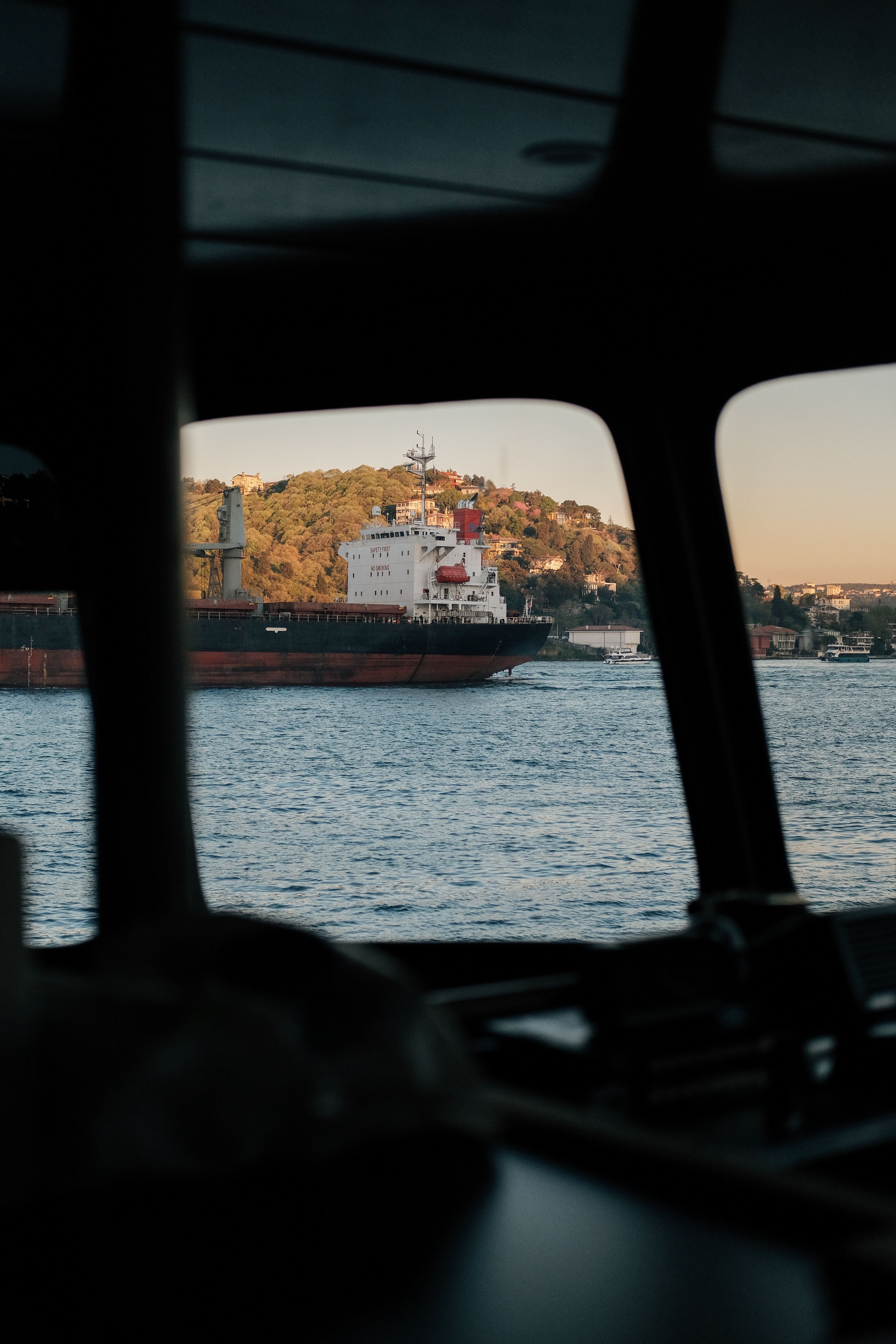 Sailing Cargo Ship behind Window · Free Stock Photo