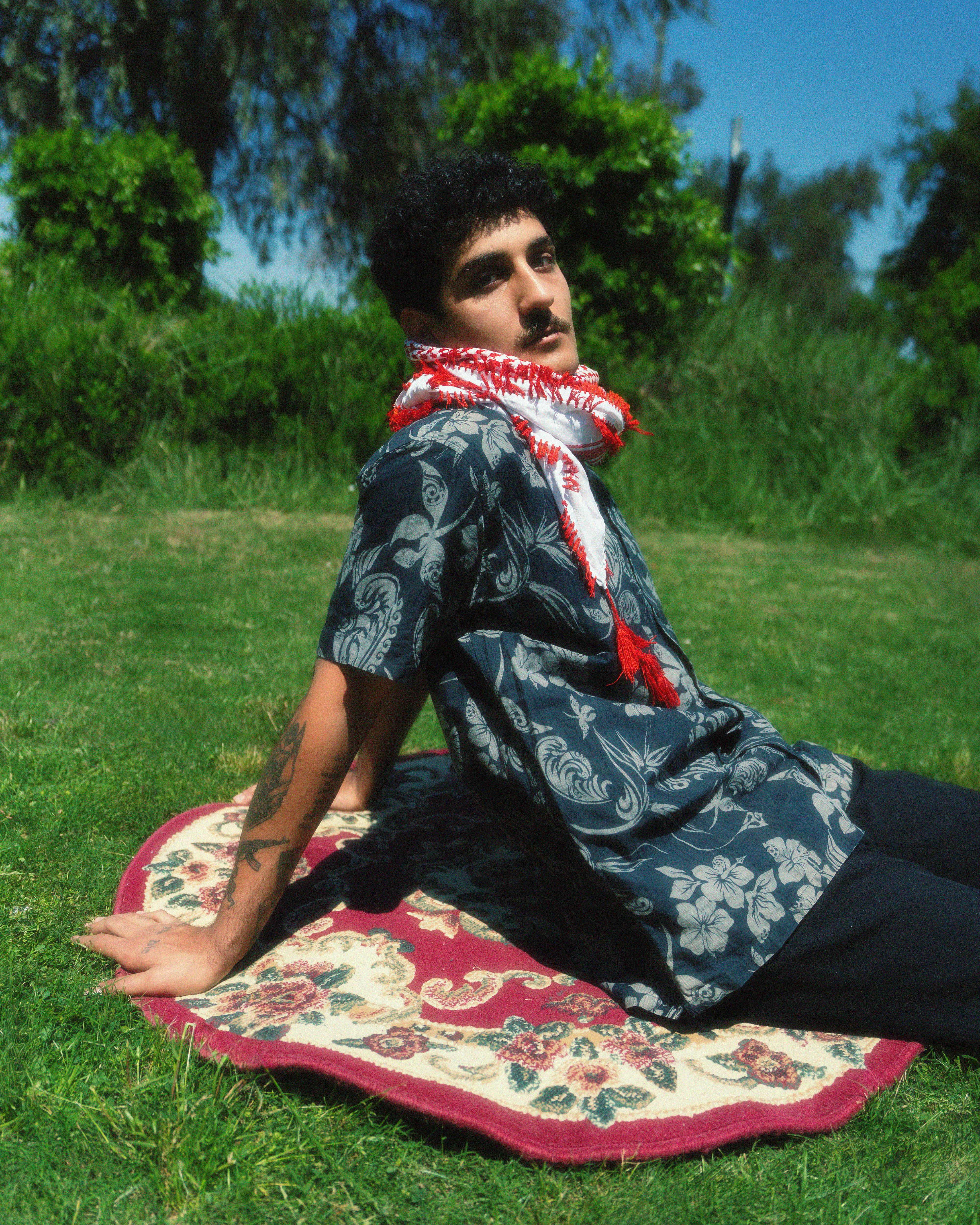 Man in Scarf Sitting on Carpet on Grass · Free Stock Photo