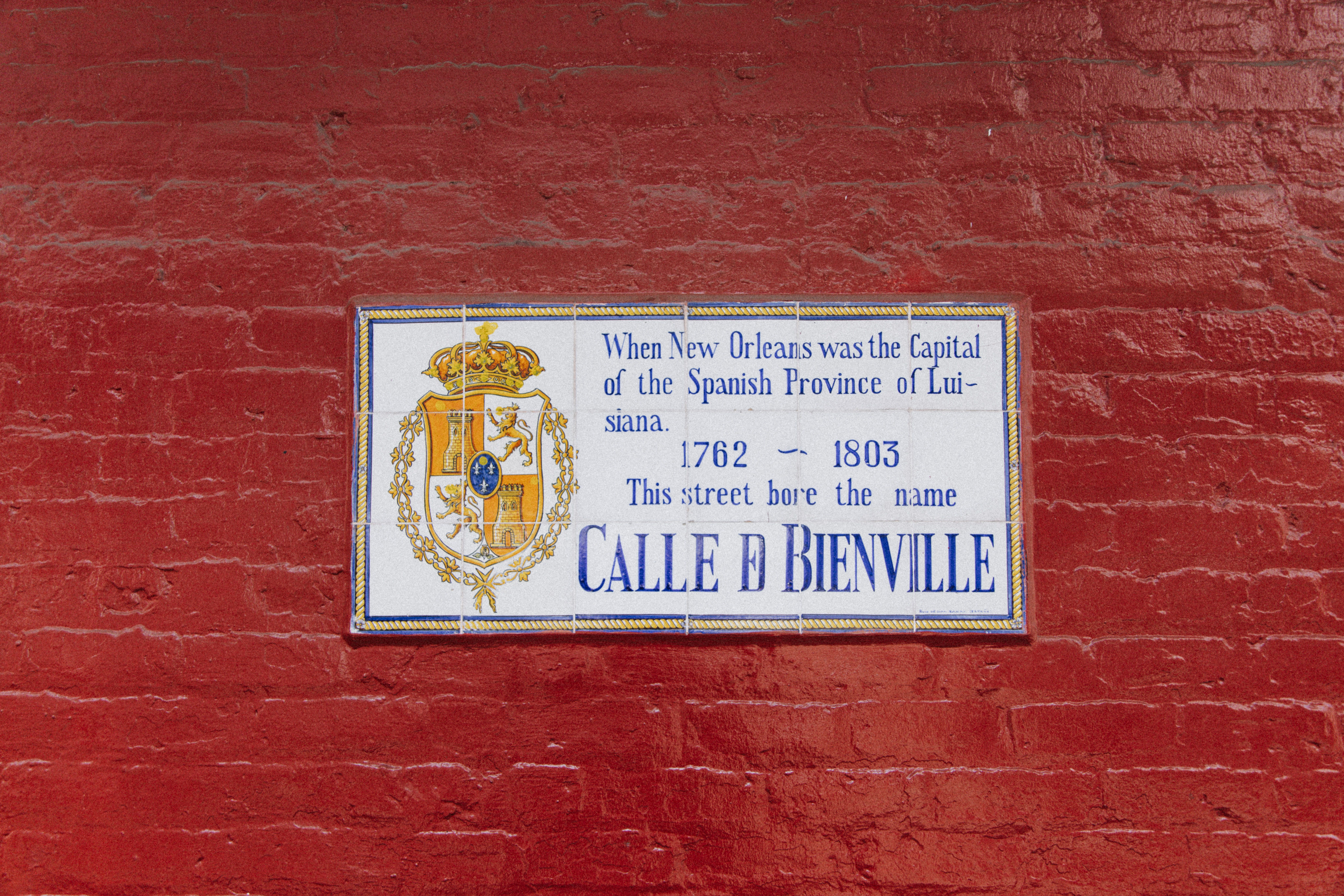 A sign on a red brick wall that says calle brouville · Free Stock Photo