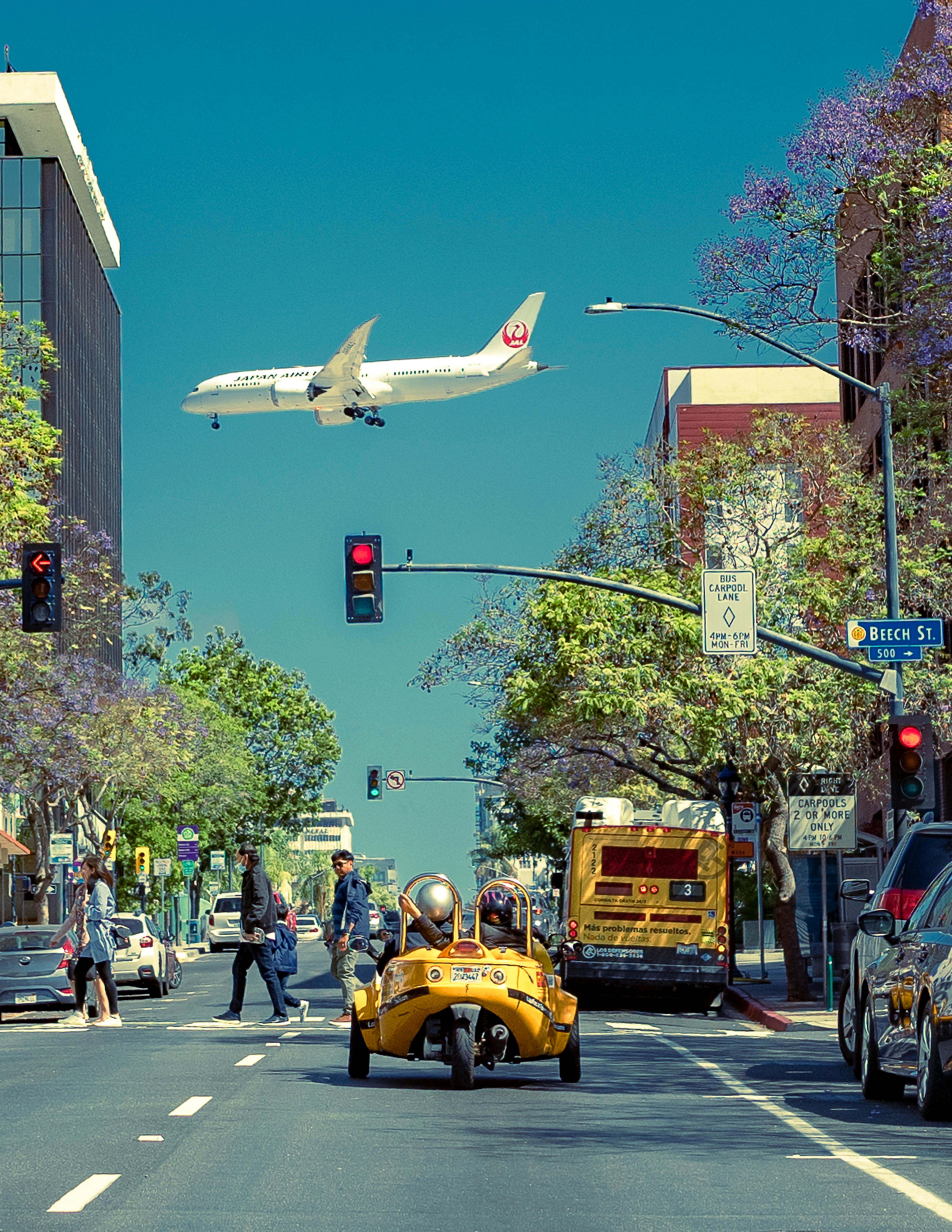 Airplane Flying over Street with Three-wheeler on Street · Free Stock Photo