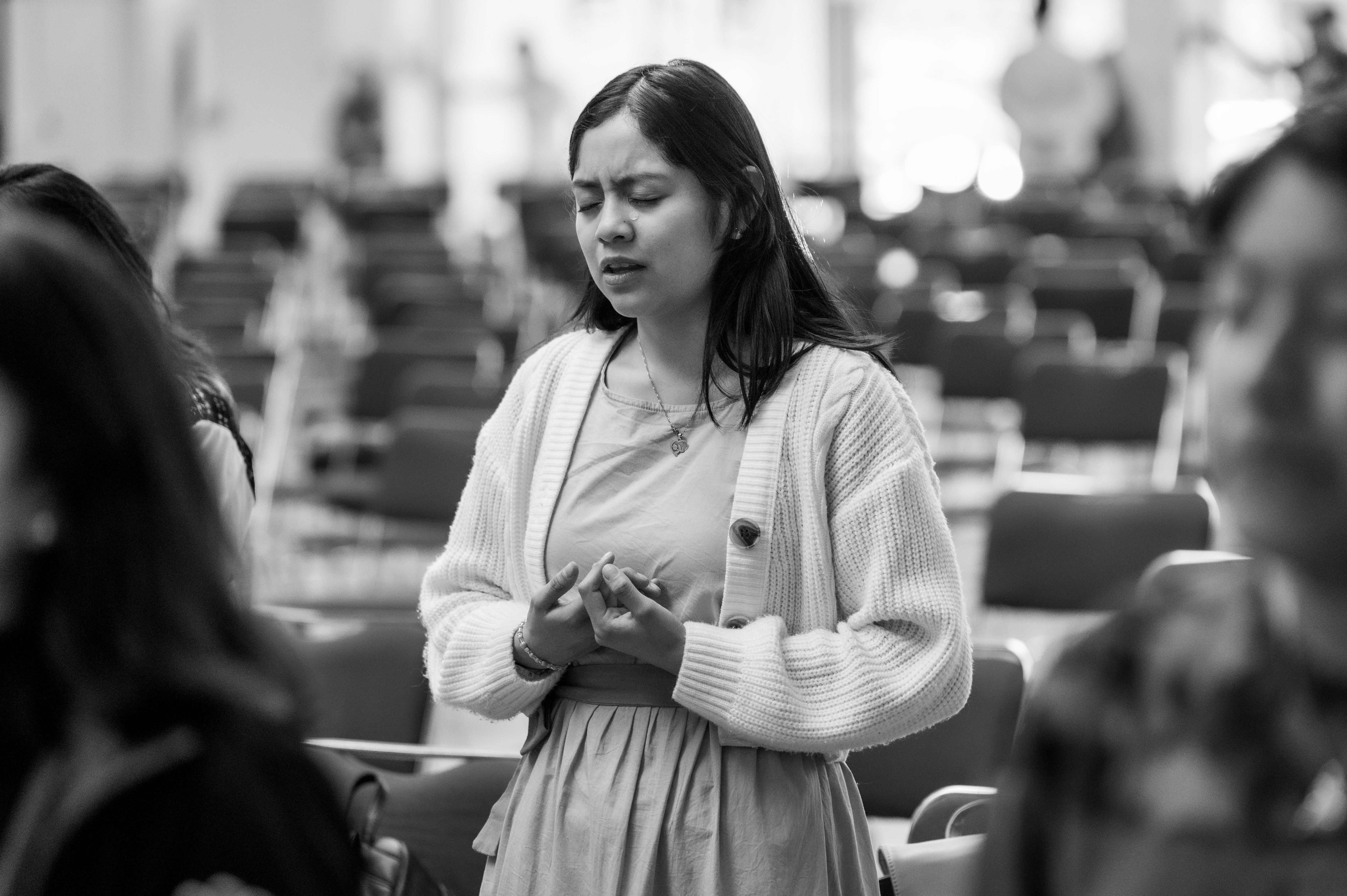 Woman Standing and Praying at Gathering · Free Stock Photo