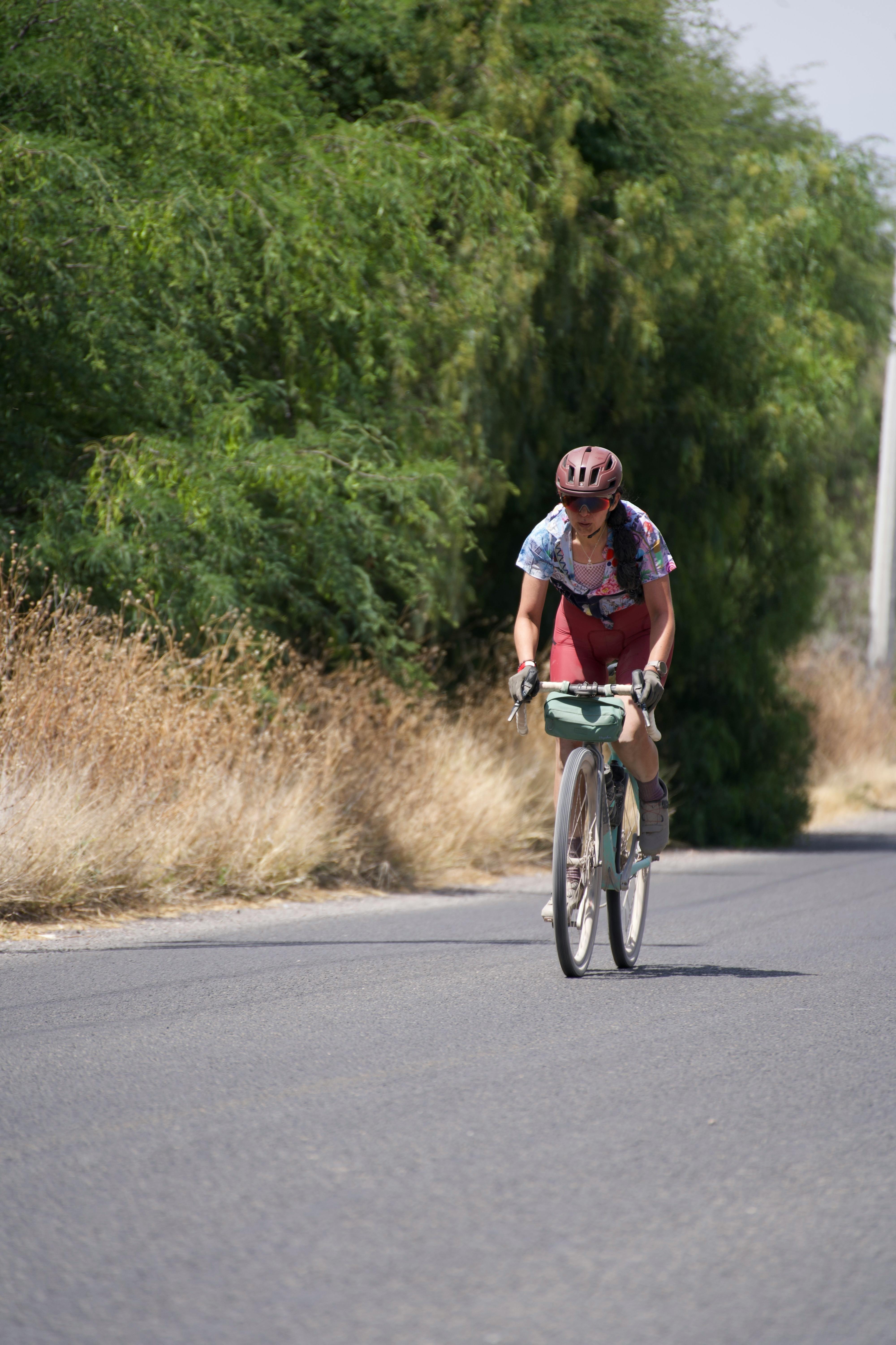 A person riding a bike on a road · Free Stock Photo