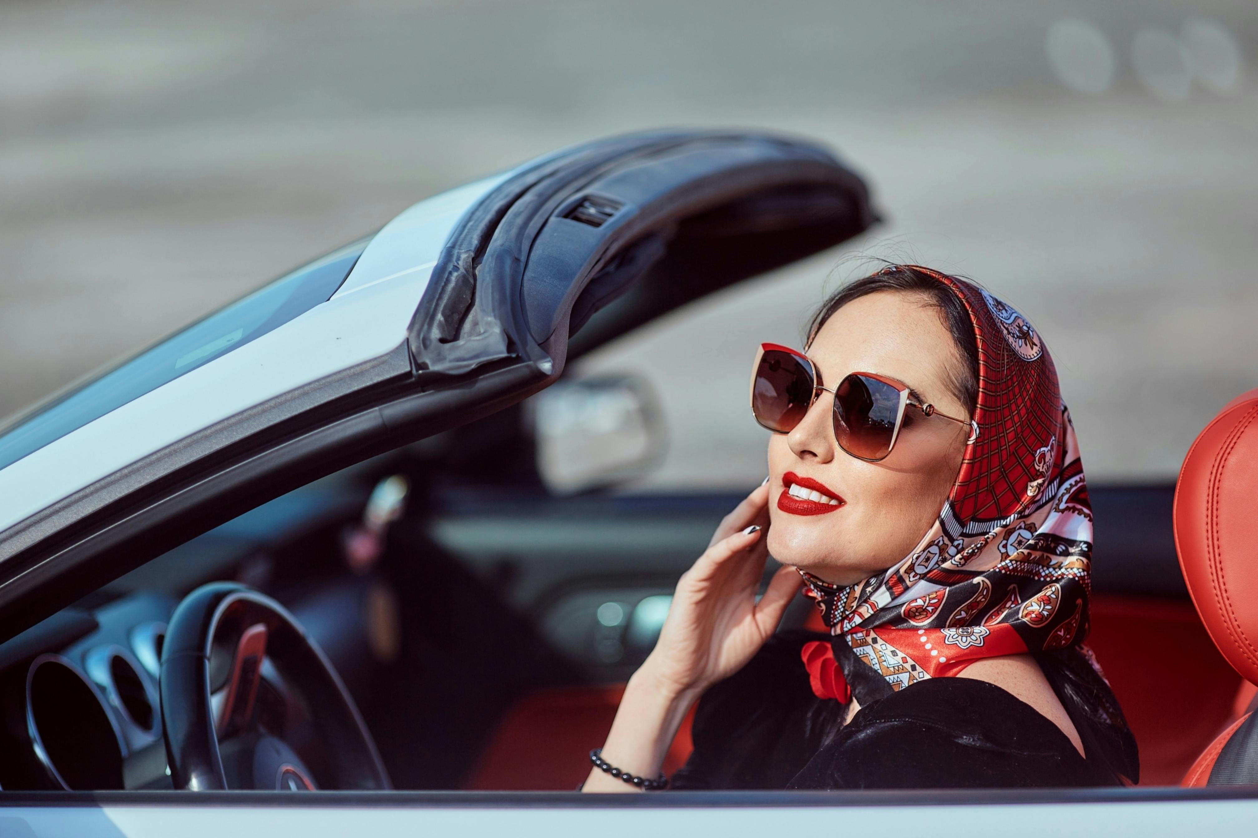 Portrait of a Woman with a Headscarf in a Convertible · Free Stock Photo