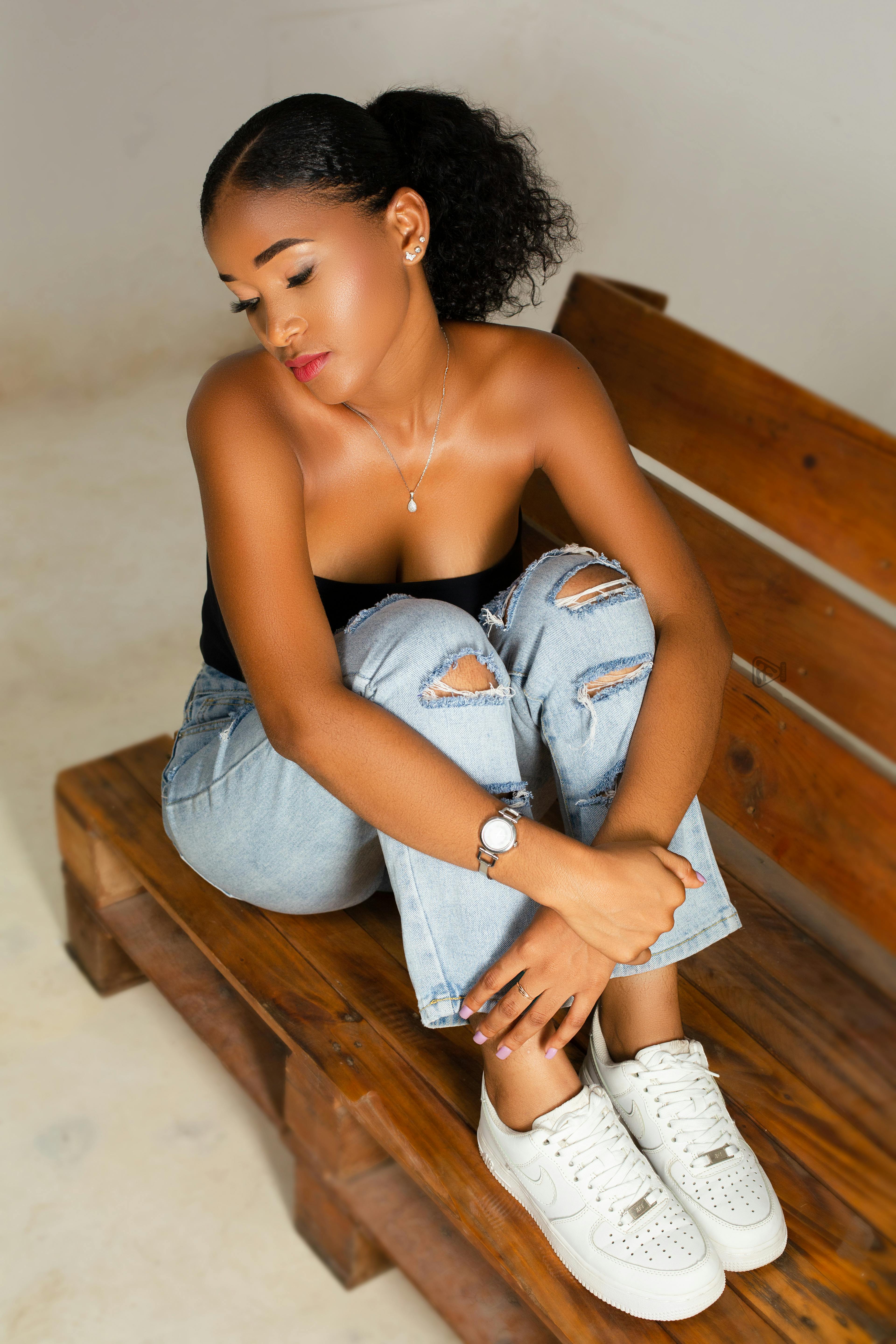 Model Posing in Strapless Black Top and Ripped Jeans · Free Stock Photo