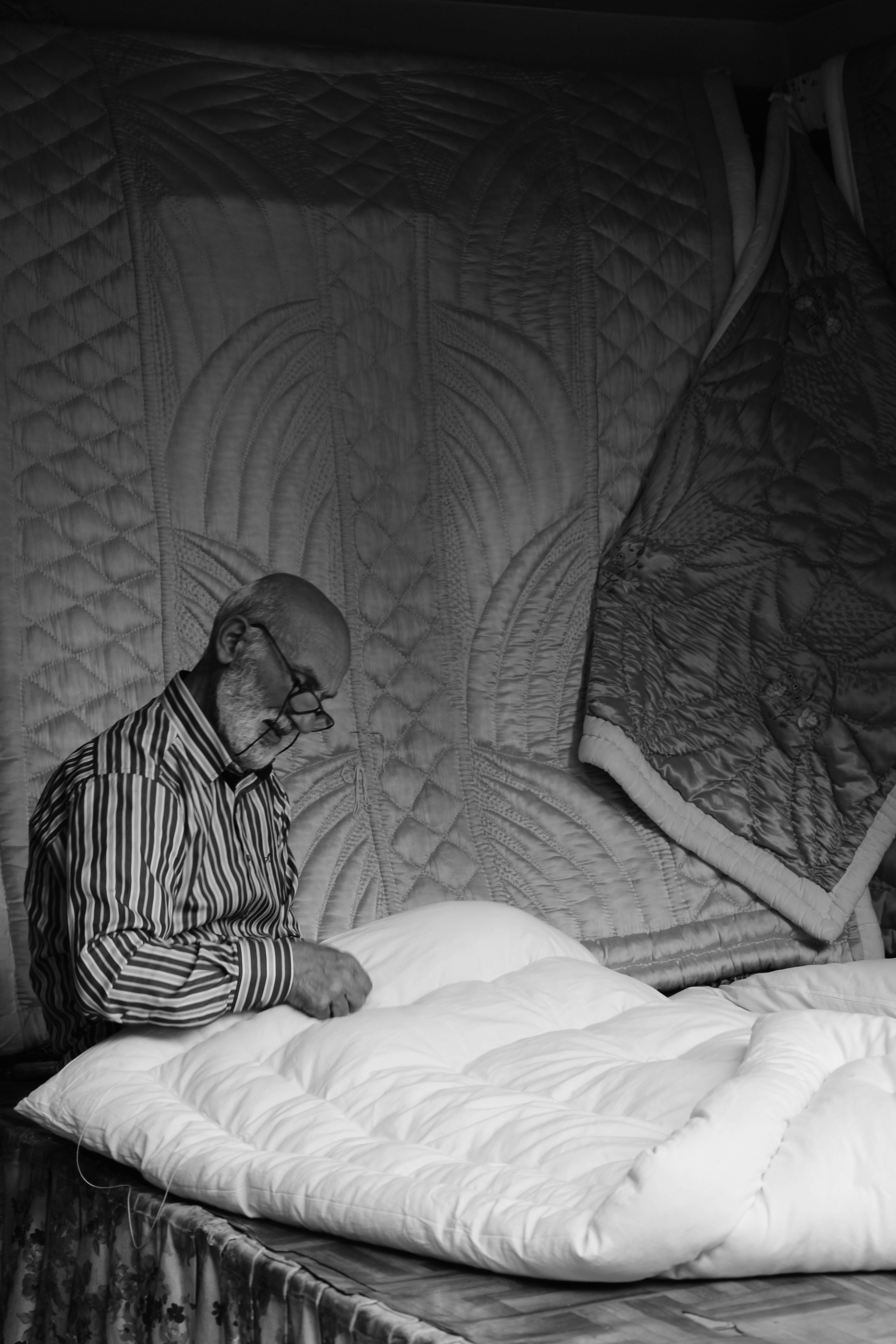 Black and White Photo of Man Stitching Duvet · Free Stock Photo