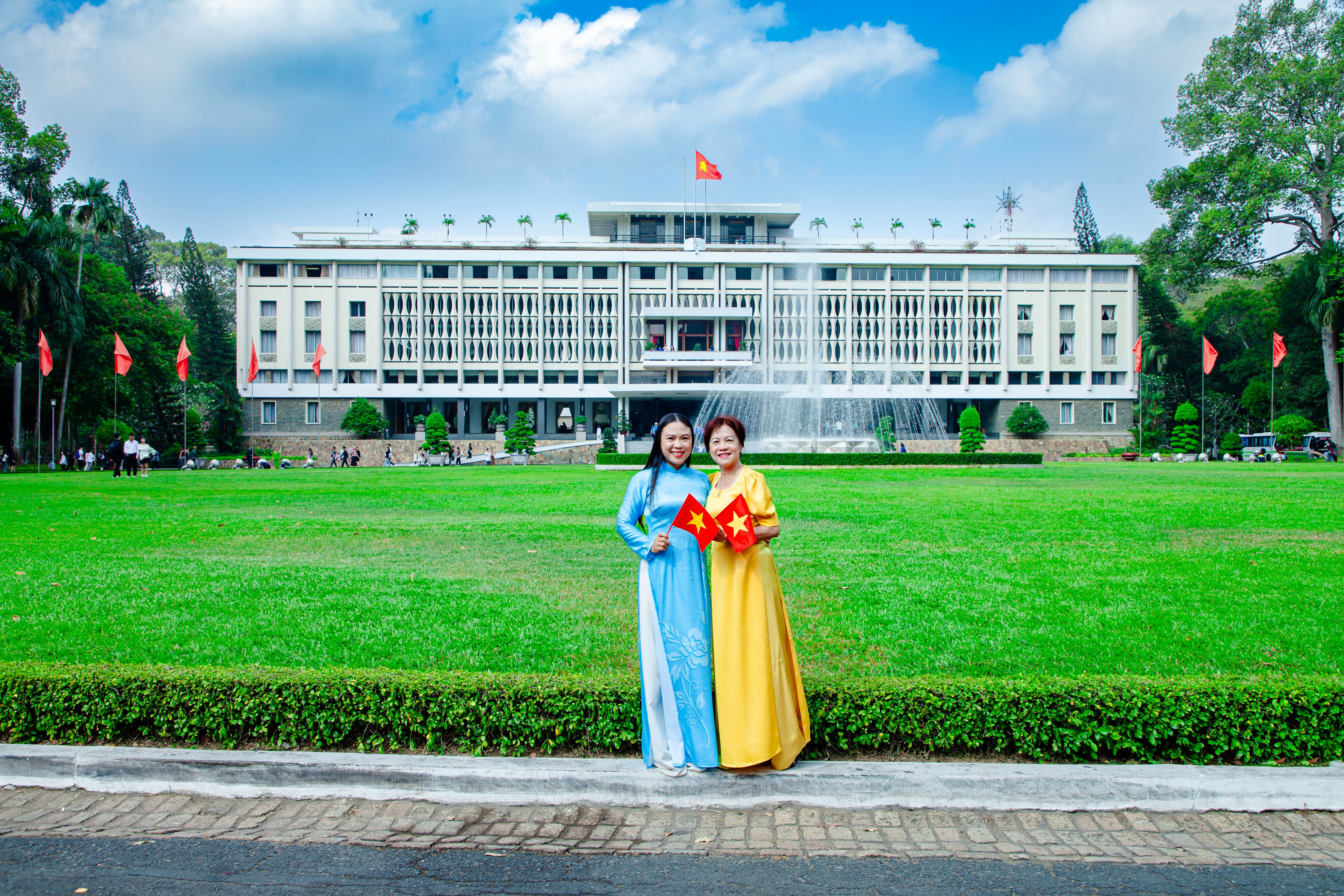 Women in Traditional Vietnamese Dresses Posing in front of Independence ...