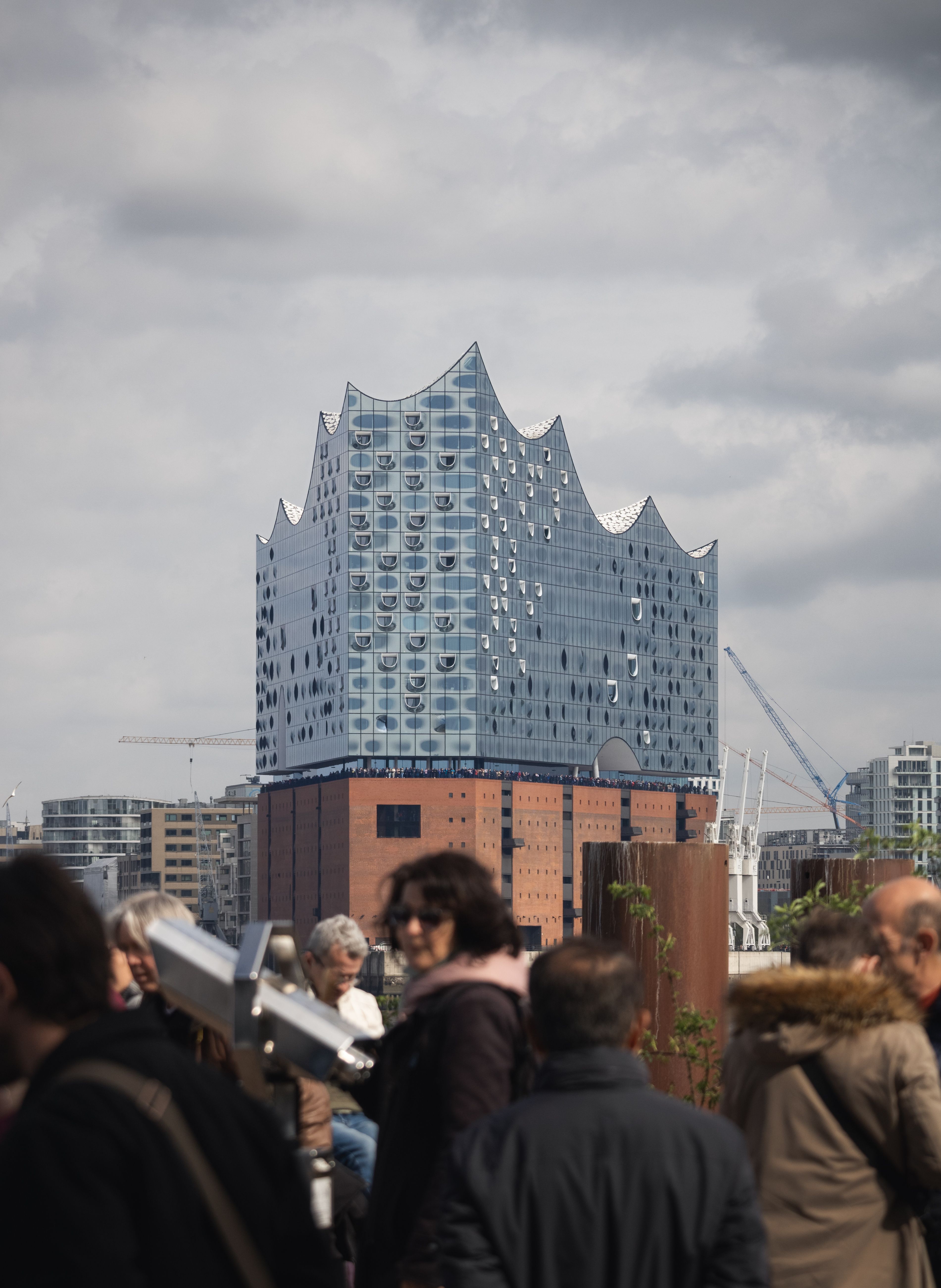 People walking by a building with a large tower · Free Stock Photo