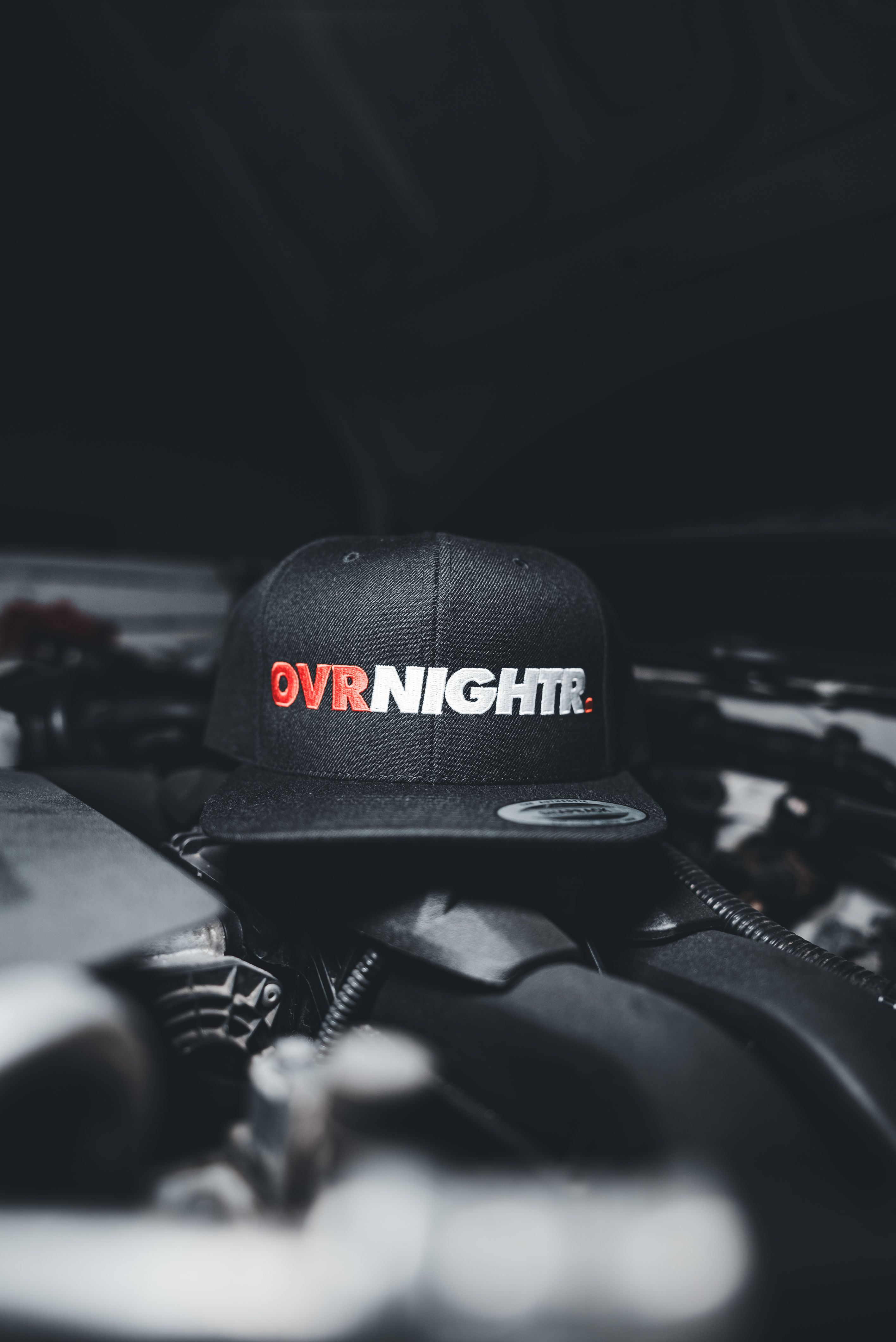 Ovrnightr Baseball Cap on a Car Engine · Free Stock Photo