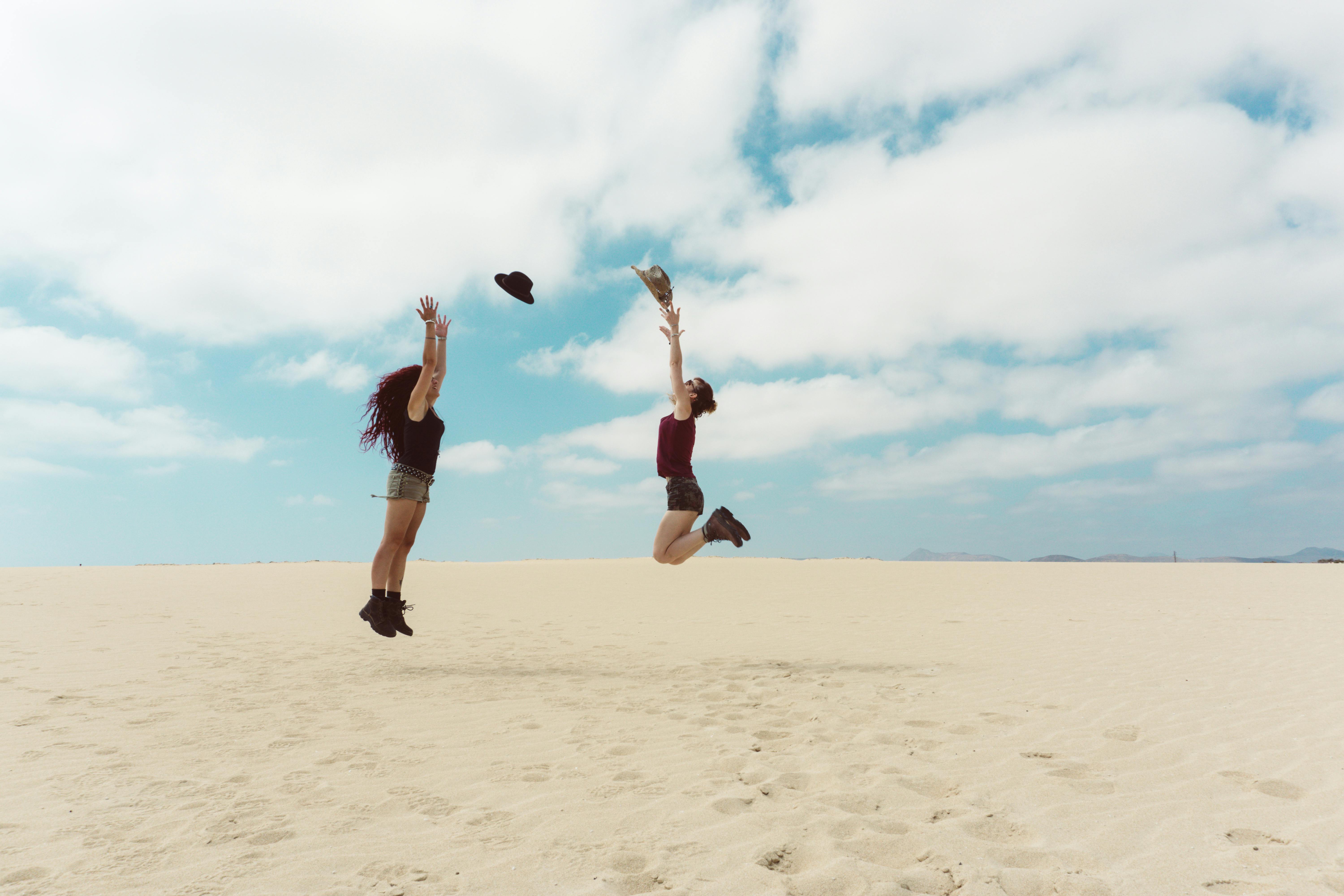 Two People Jumping on a Beach · Free Stock Photo
