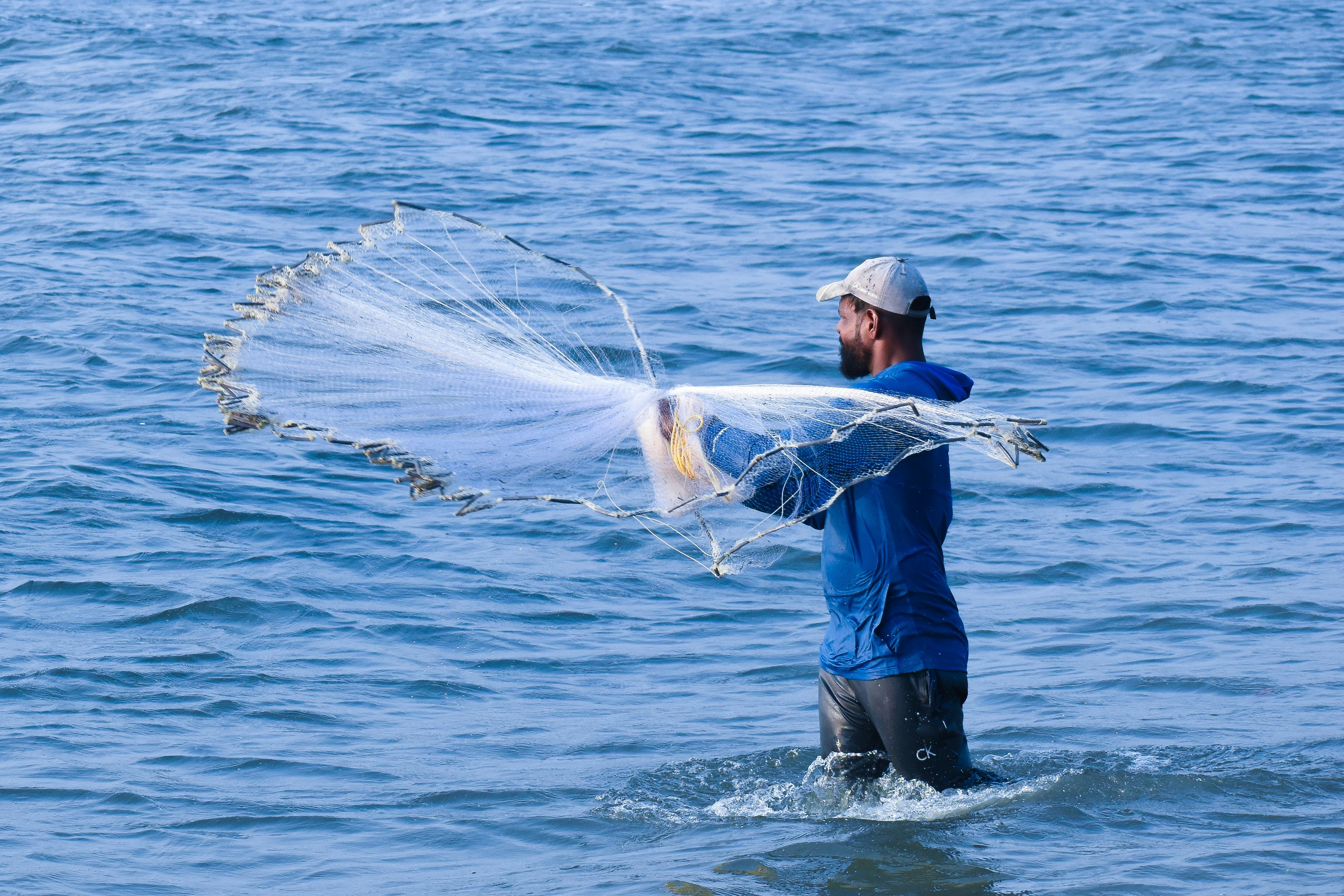 Fisherman Standing with Net in Water · Free Stock Photo