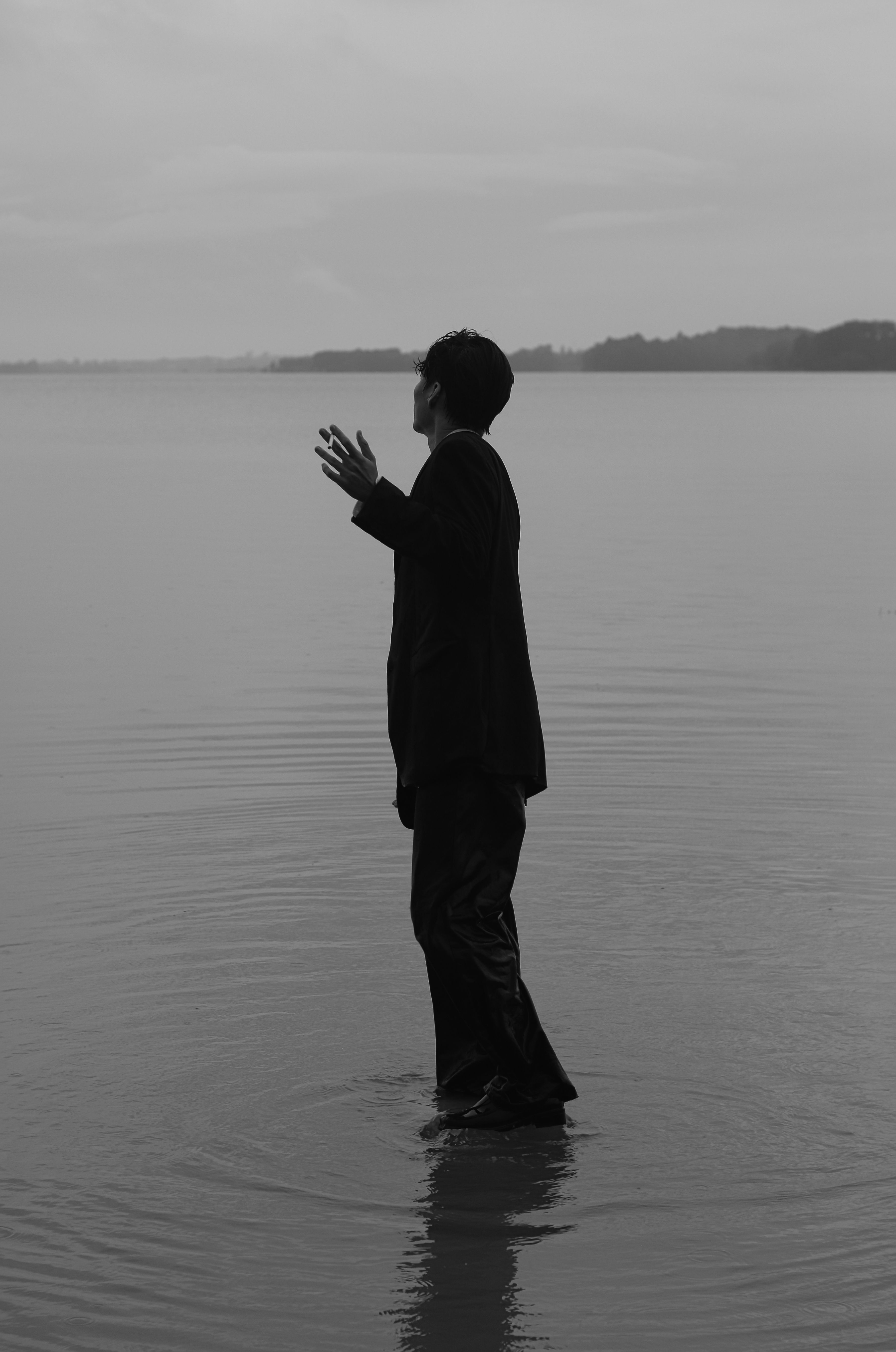 A man standing in the water with his arms outstretched · Free Stock Photo
