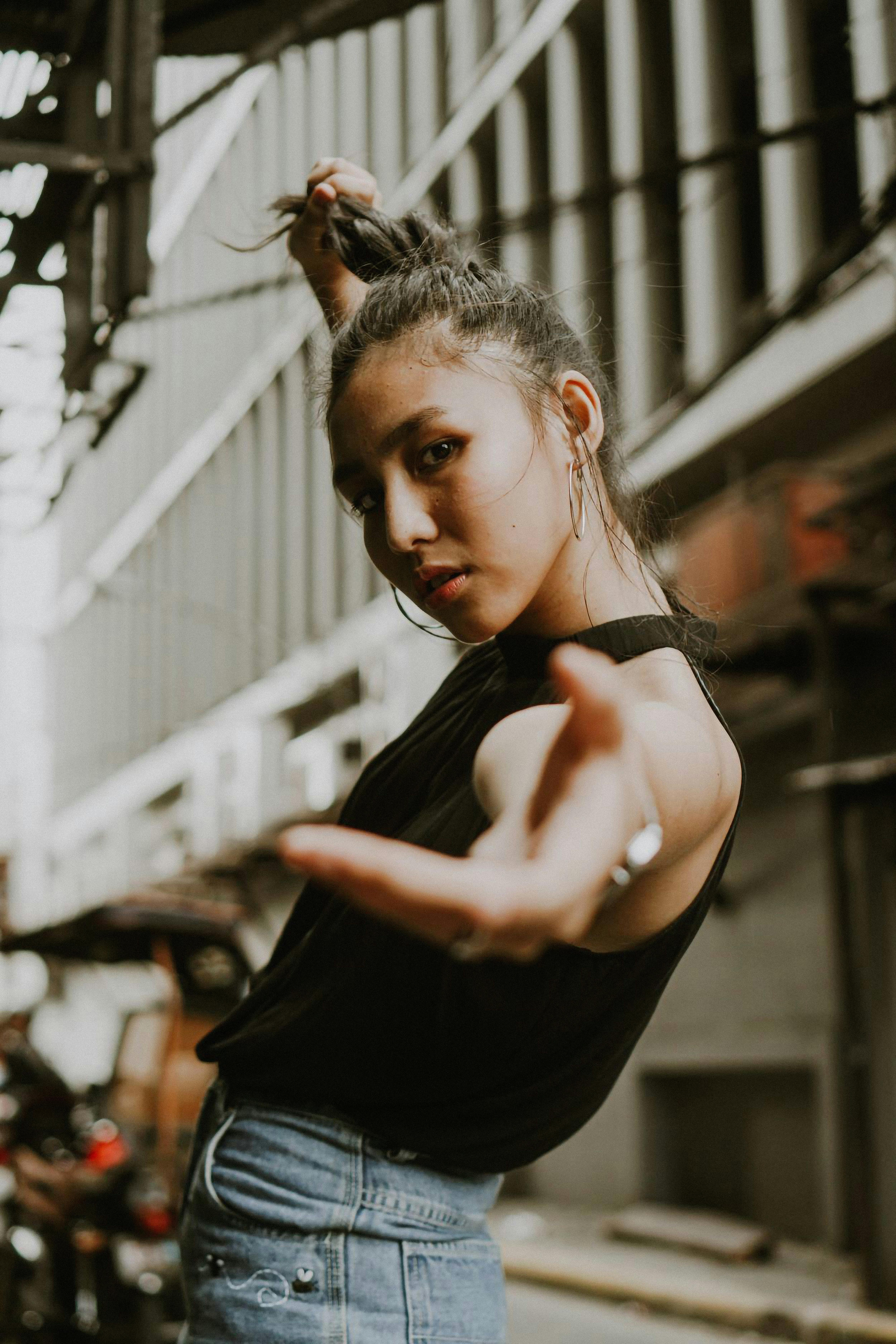 Brunette Woman in Black Top Posing with Hand Extended Toward Camera ...