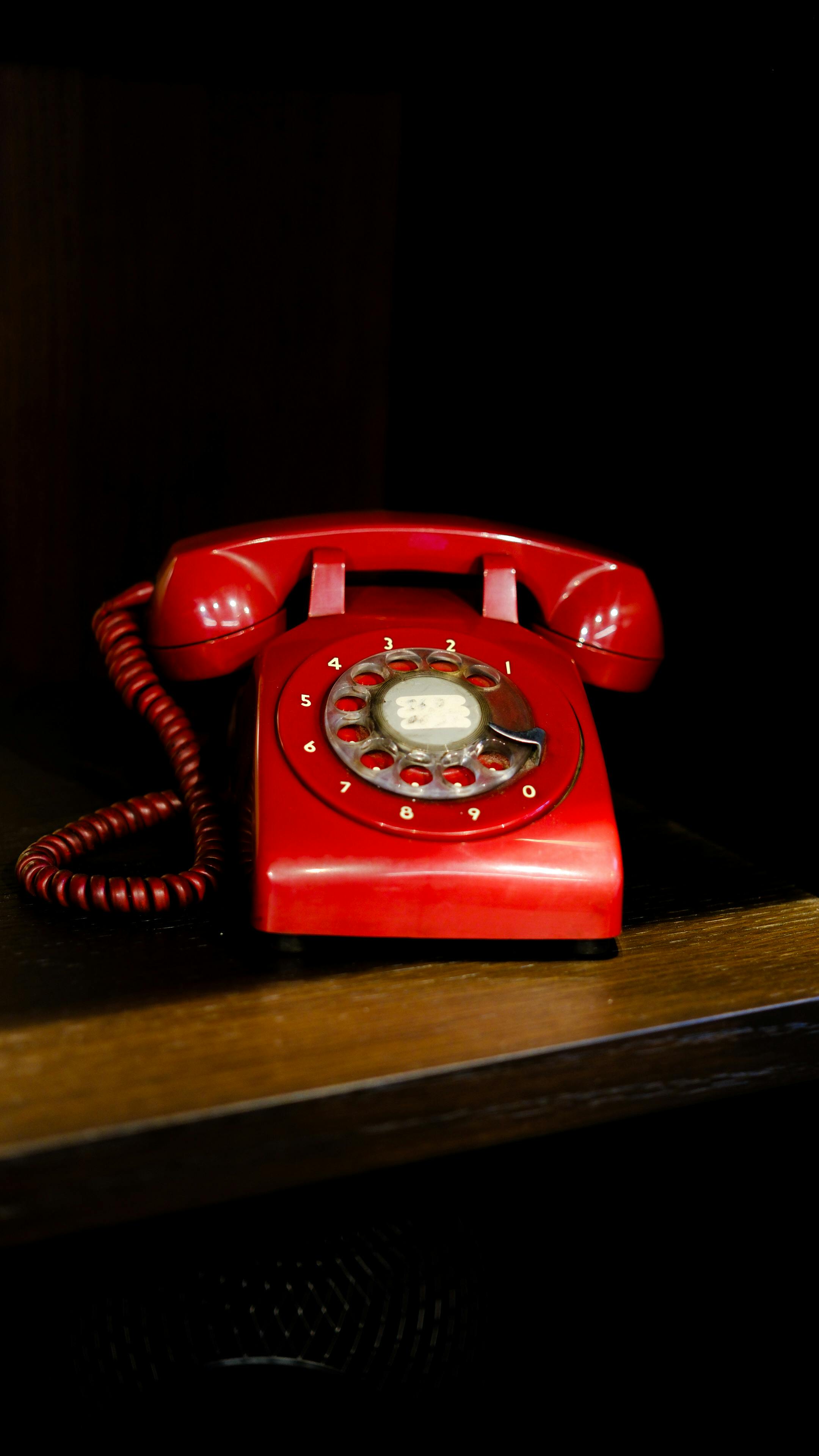 Red Vintage Telephone on a Dark Shelf · Free Stock Photo