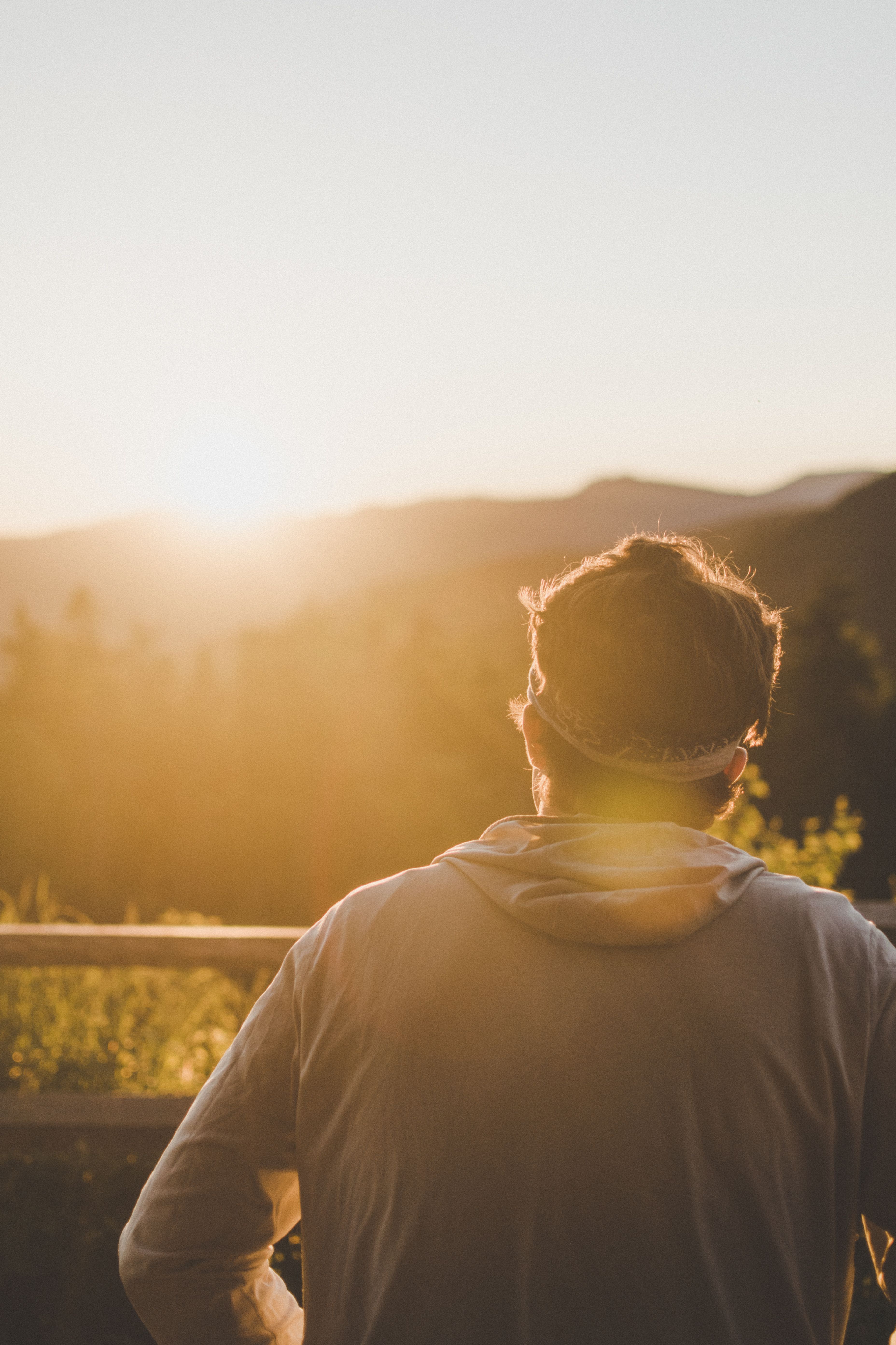 Man in Hoodie Looking at Sunset over Mountains · Free Stock Photo