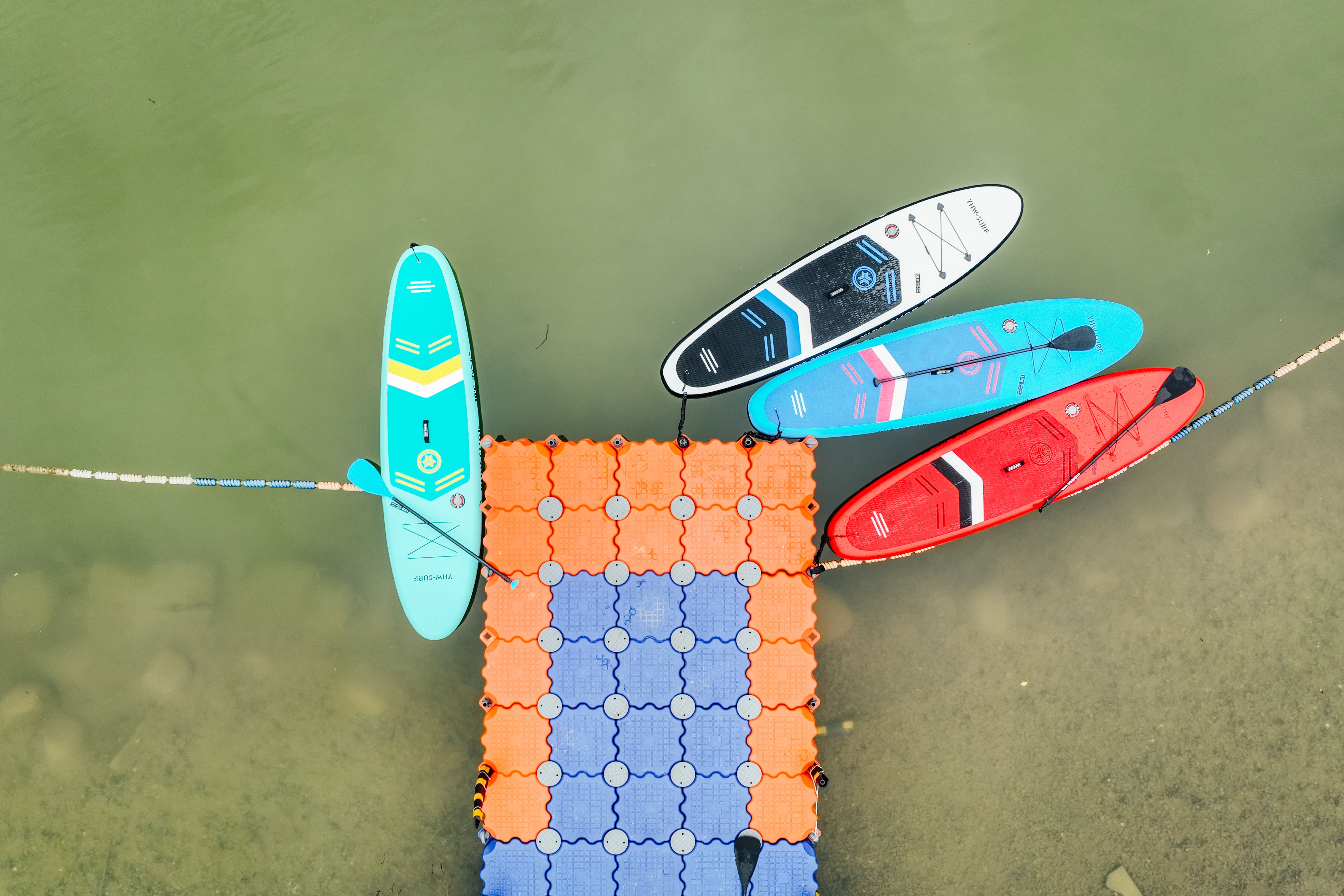 Three paddle boards are sitting on a dock · Free Stock Photo