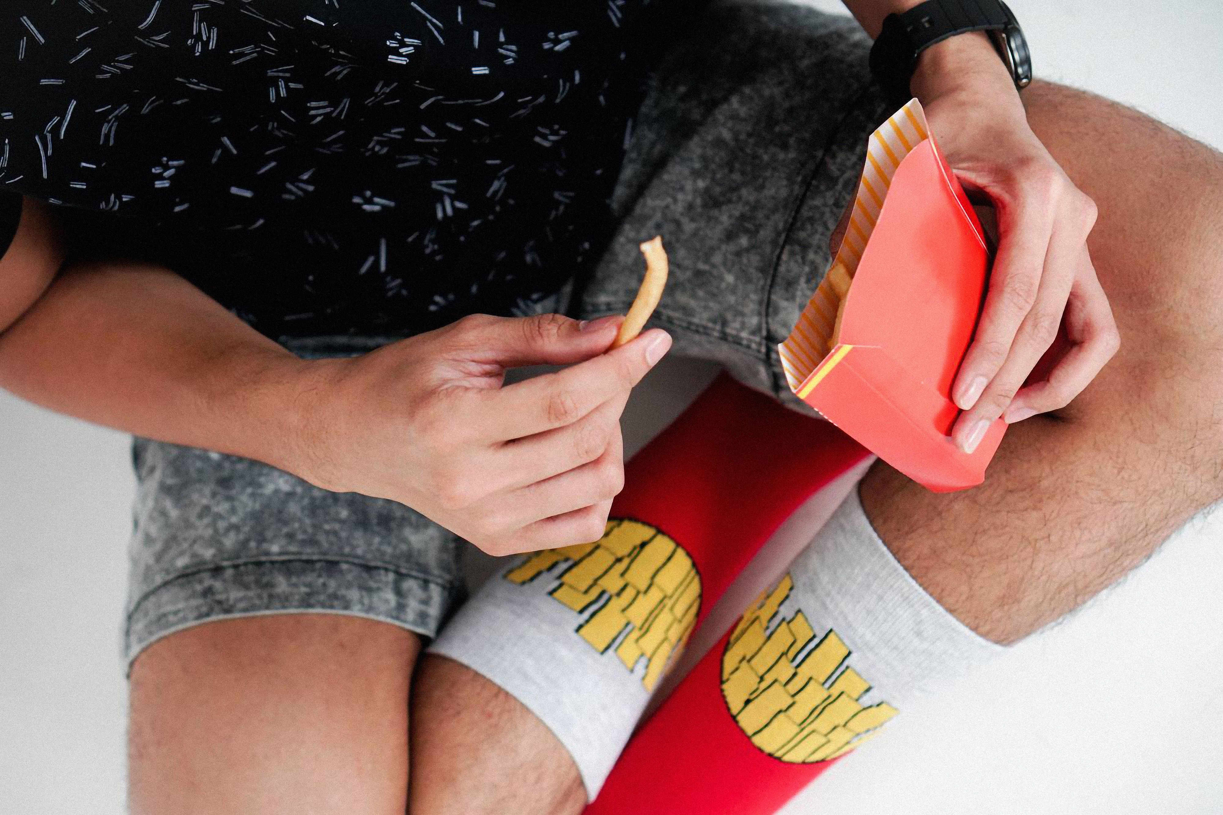 Man in Mcdonalds Socks Eating French Fries · Free Stock Photo