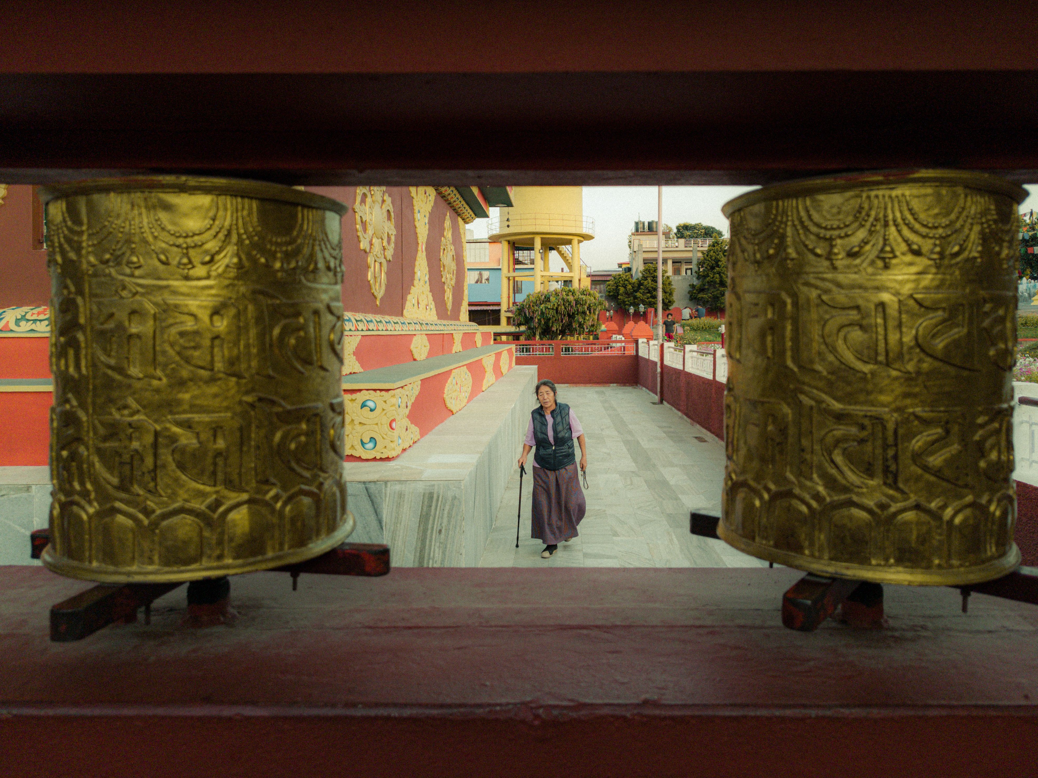 Woman Walking behind Bells at Buddhist Temple · Free Stock Photo