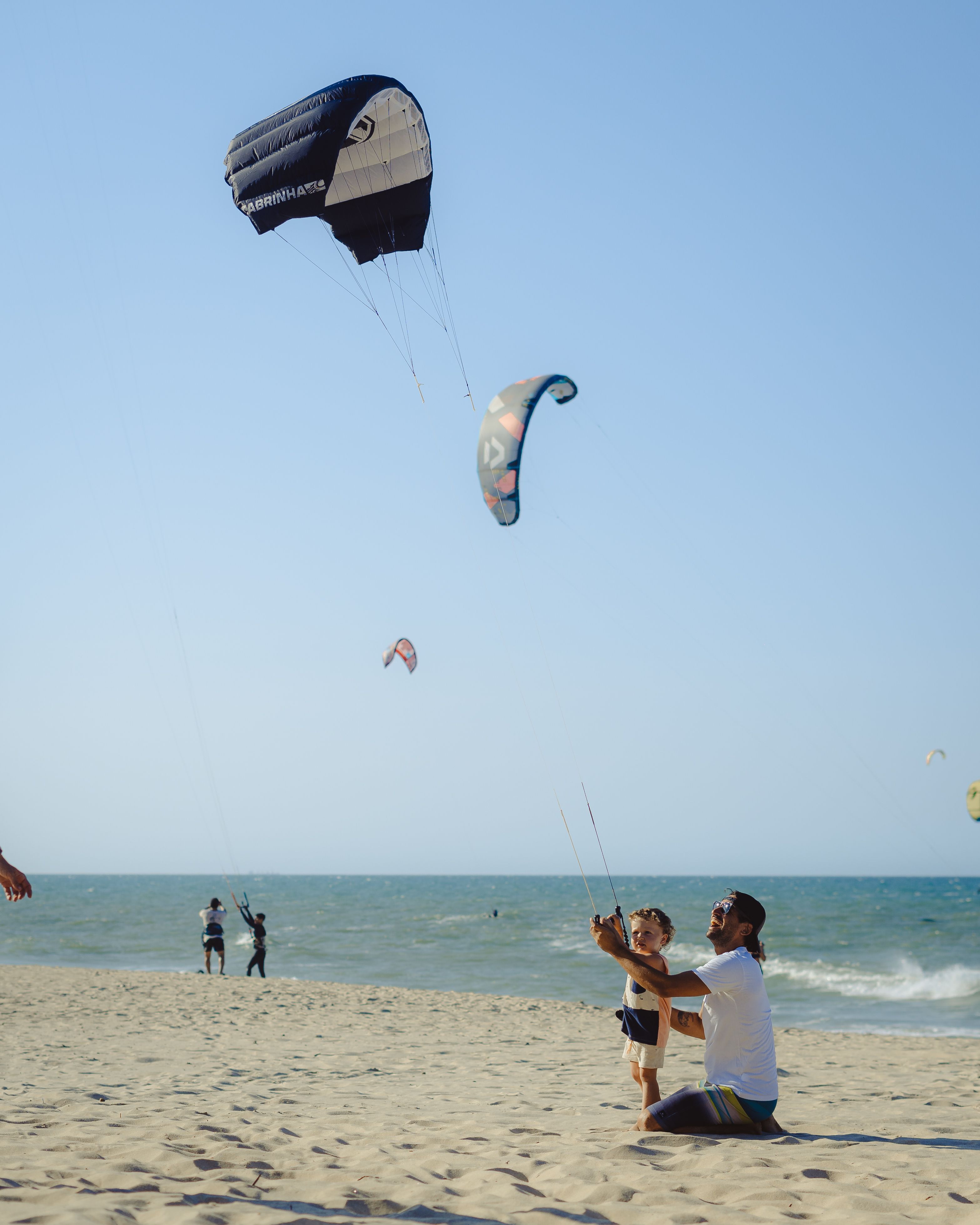 Father with a Daughter Flying Kites on a Beach · Free Stock Photo
