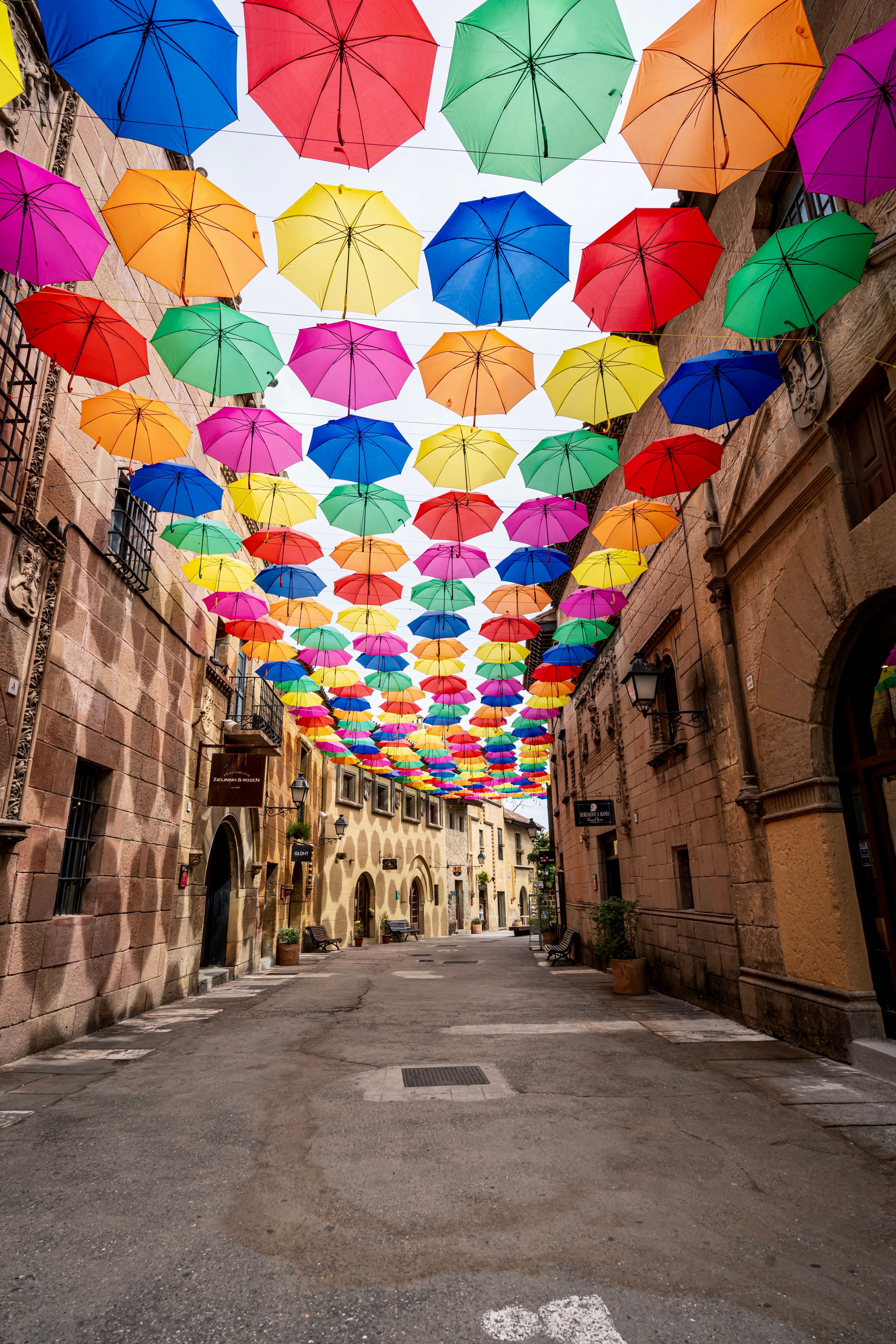 Multicolored Umbrella Hung Outside Brown Wooden House · Free Stock Photo