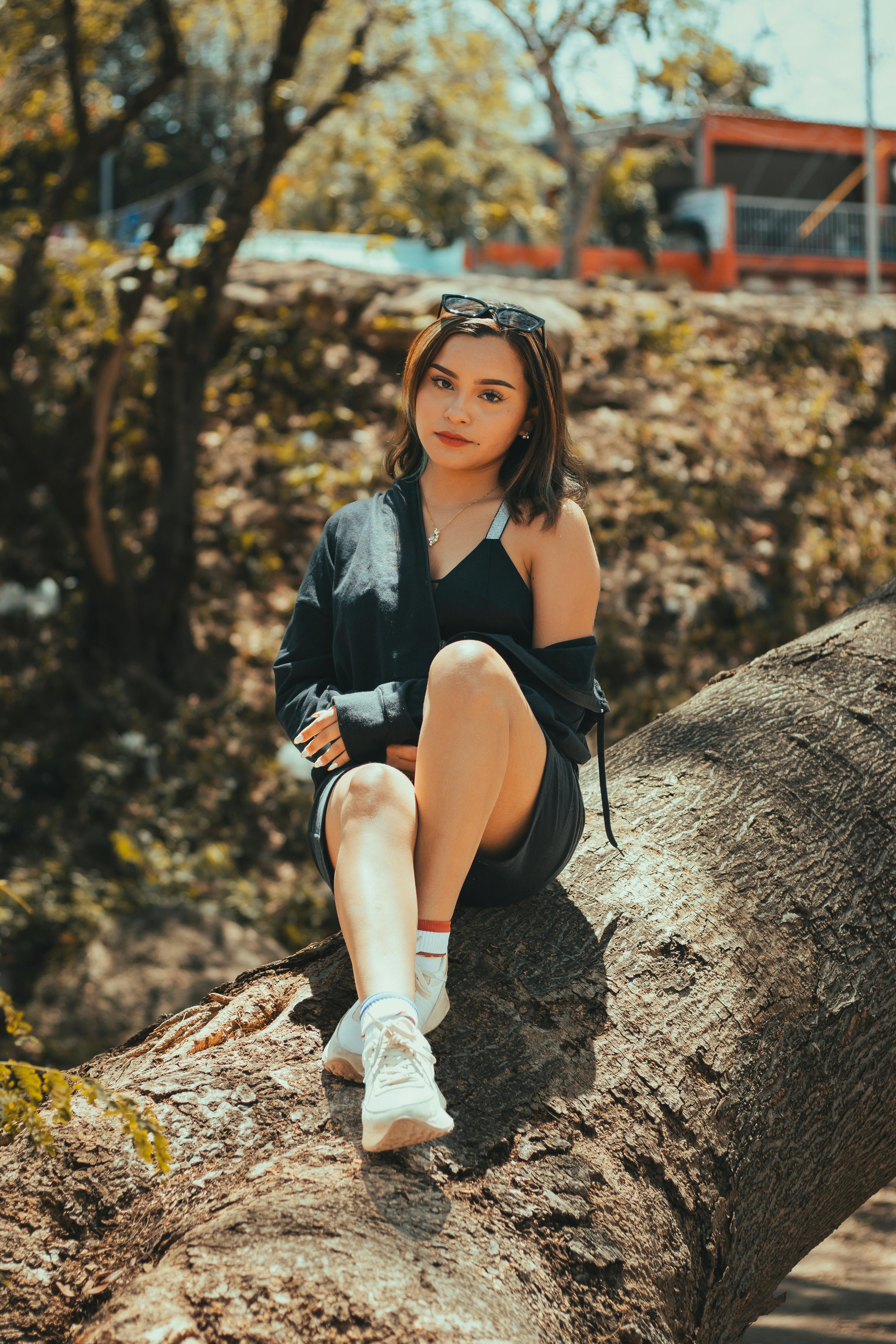 Woman Sitting on Tree Trunk · Free Stock Photo