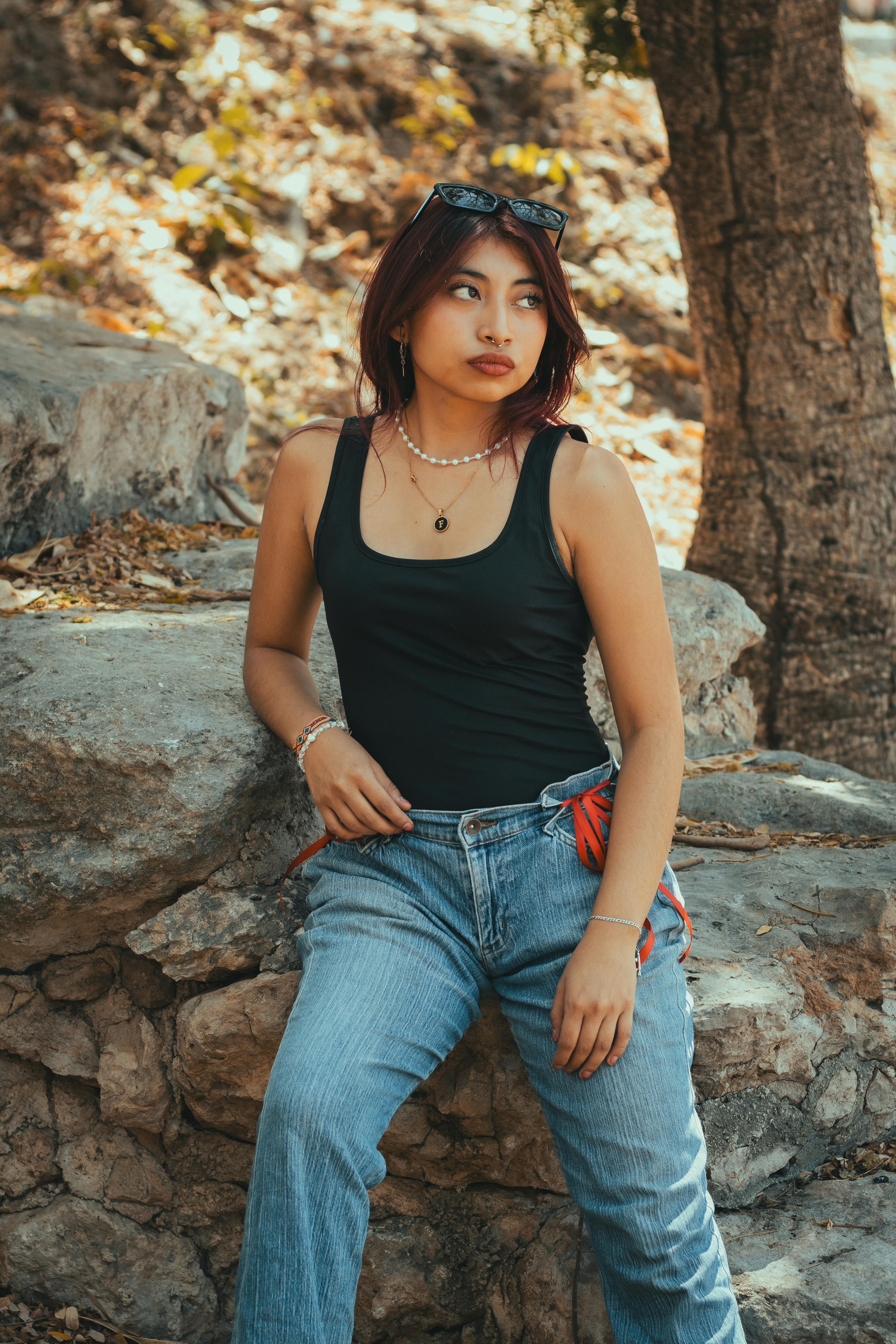 Trendy woman resting on rough rocks in summer · Free Stock Photo