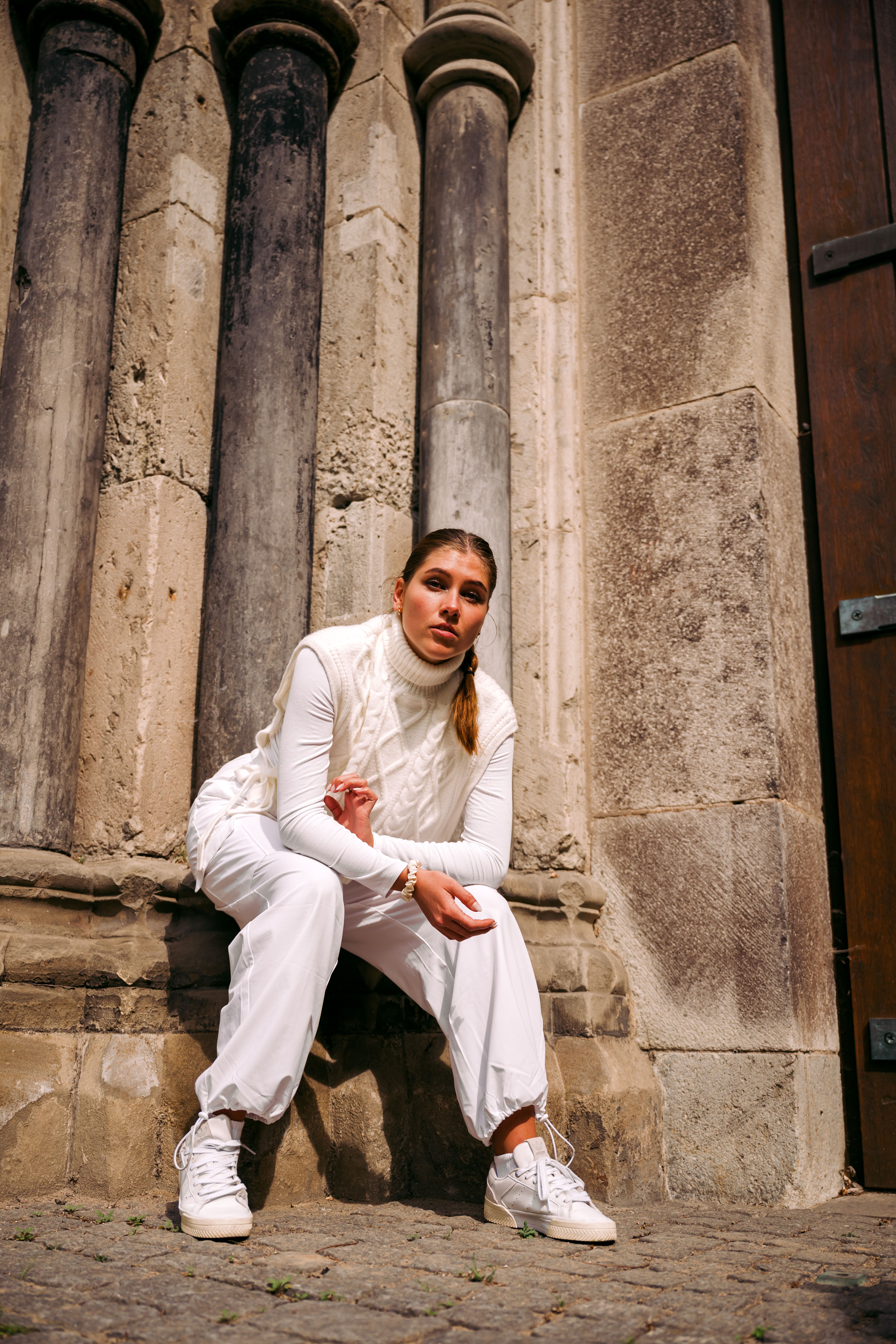 Woman Sitting by a Building · Free Stock Photo