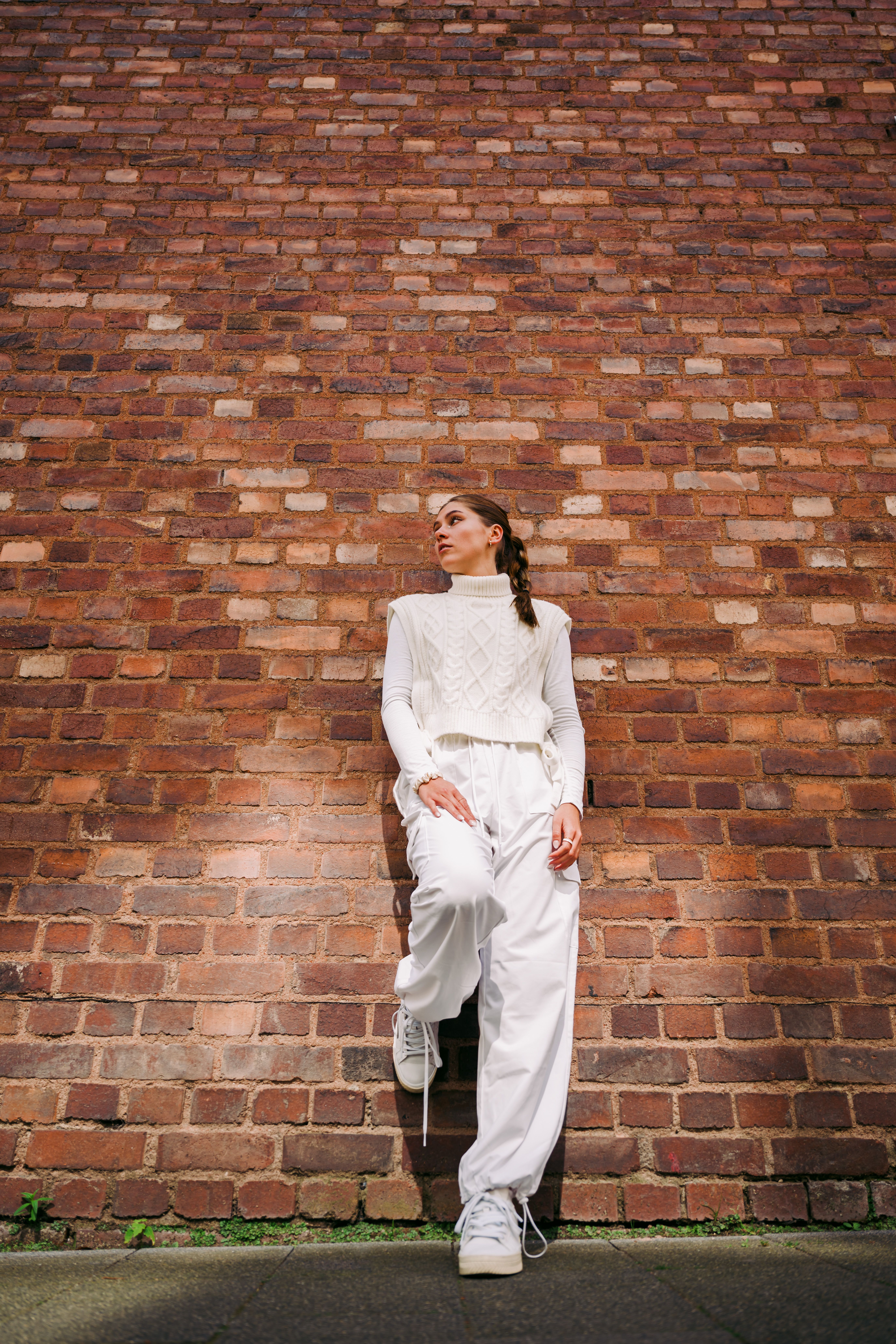 Model in White Clothes Against a Brick Wall · Free Stock Photo