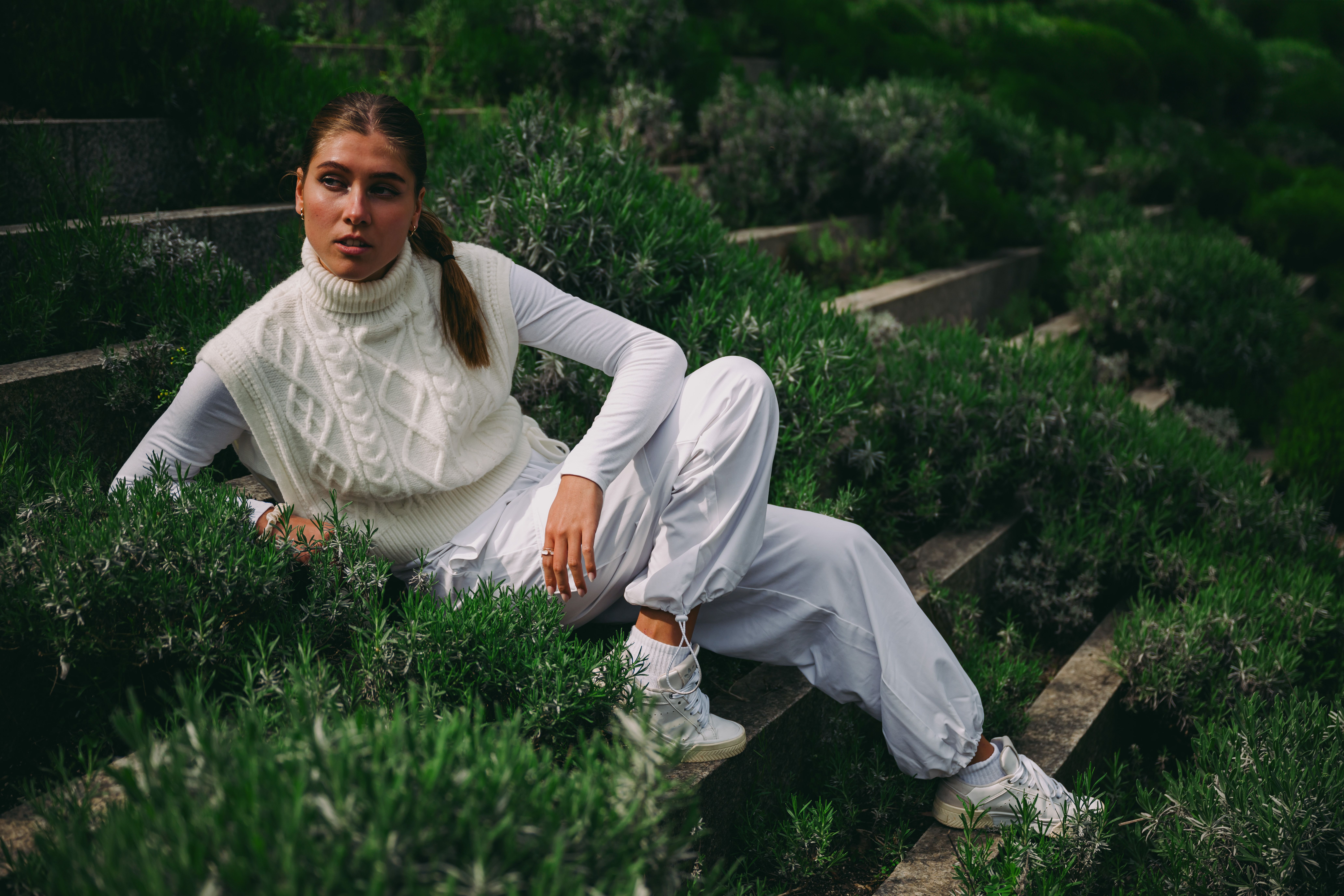 Model in White Clothes Sitting in a Stepped Garden · Free Stock Photo