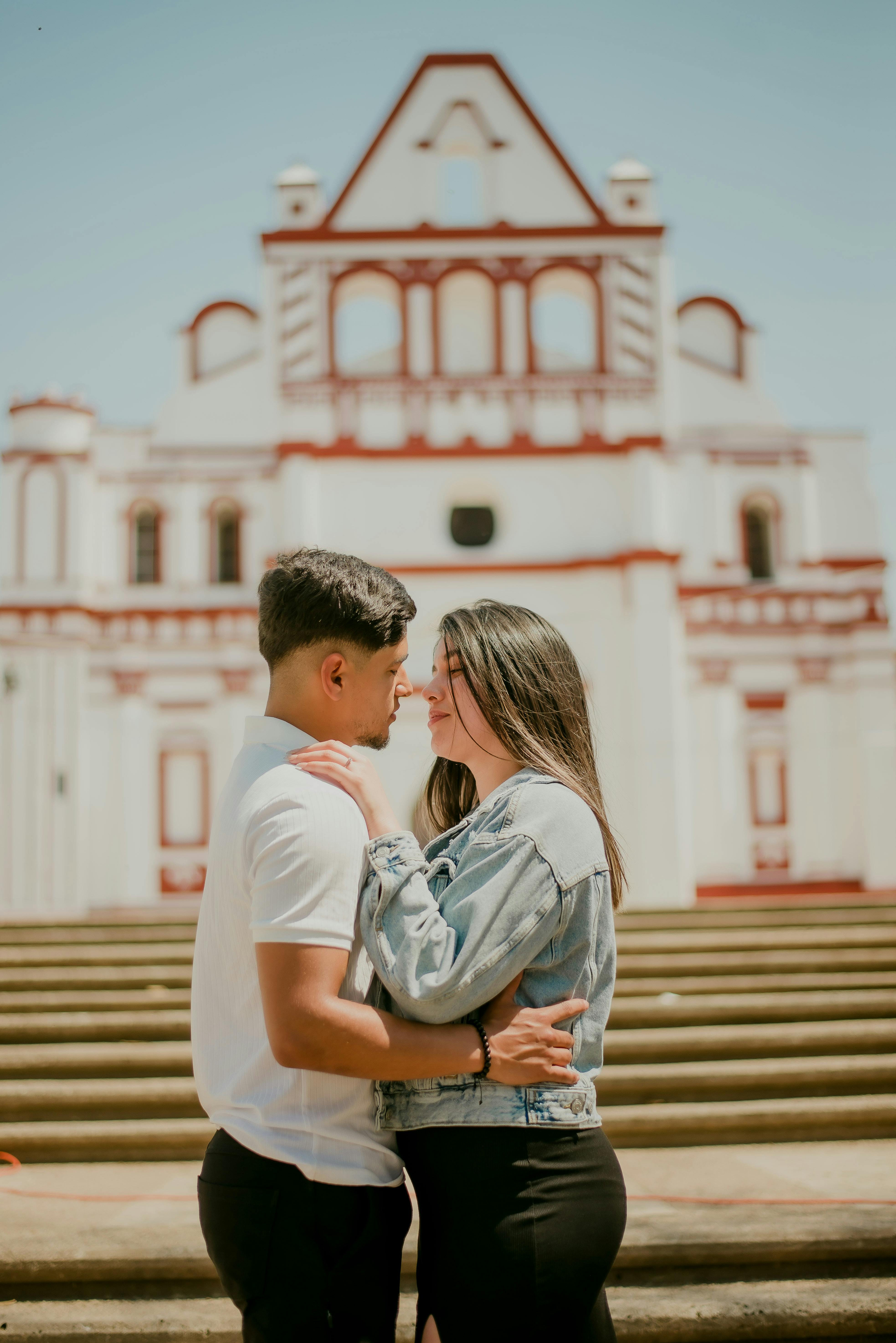 Portrait of Couple Hugging in front of Church · Free Stock Photo